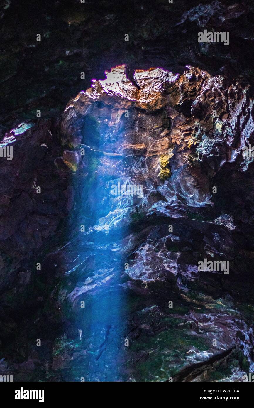 Inside of a beautiful cave with a hole and sunlight shining through ...