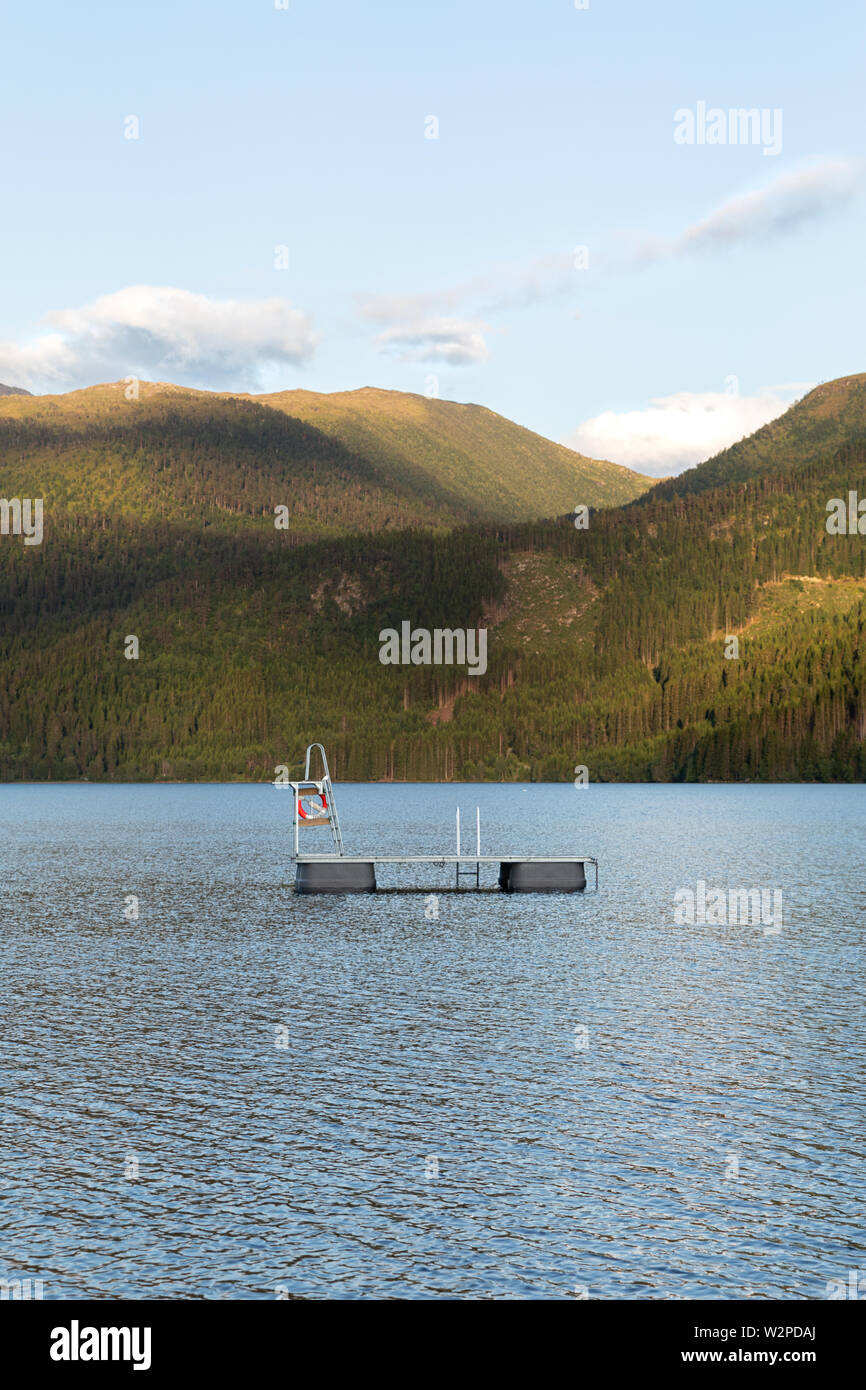 Floating swim platform with life ring in lake beneath mountains in ...