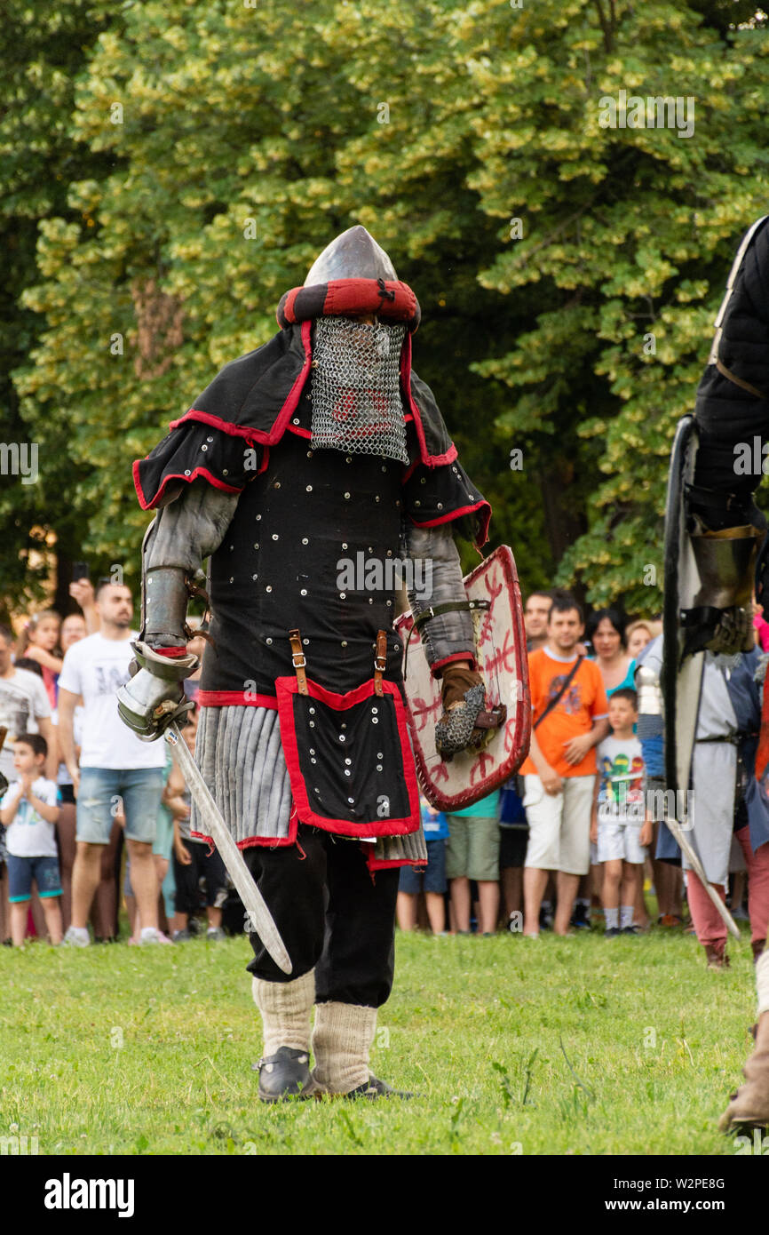 Nis, Serbia - June 15. 2019 Knight with red armor and with sword and ...