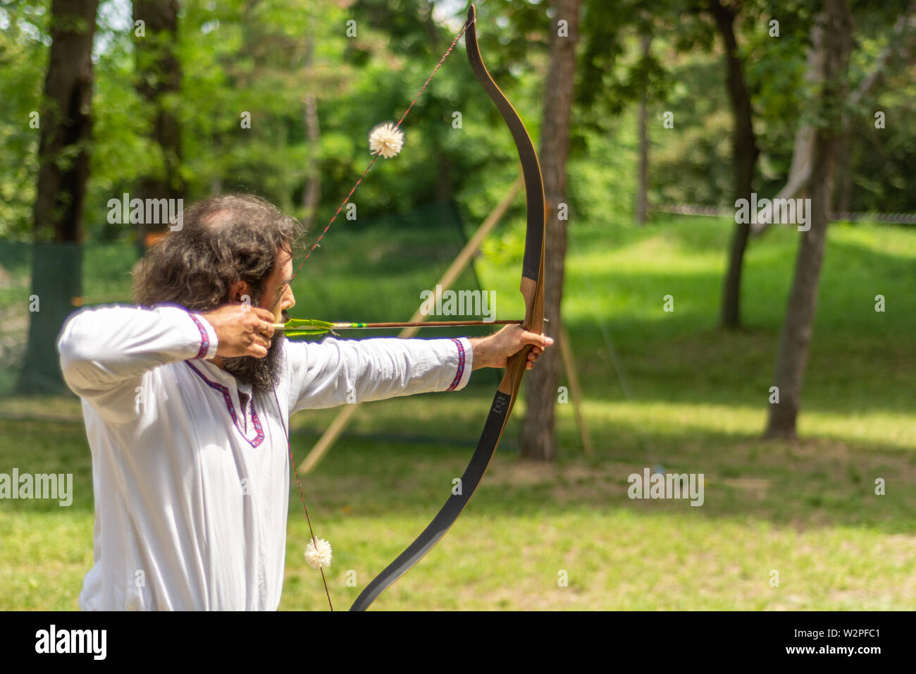 Nis, Serbia - June 16. 2019 Archer with bow shoot arrow in the forest ...