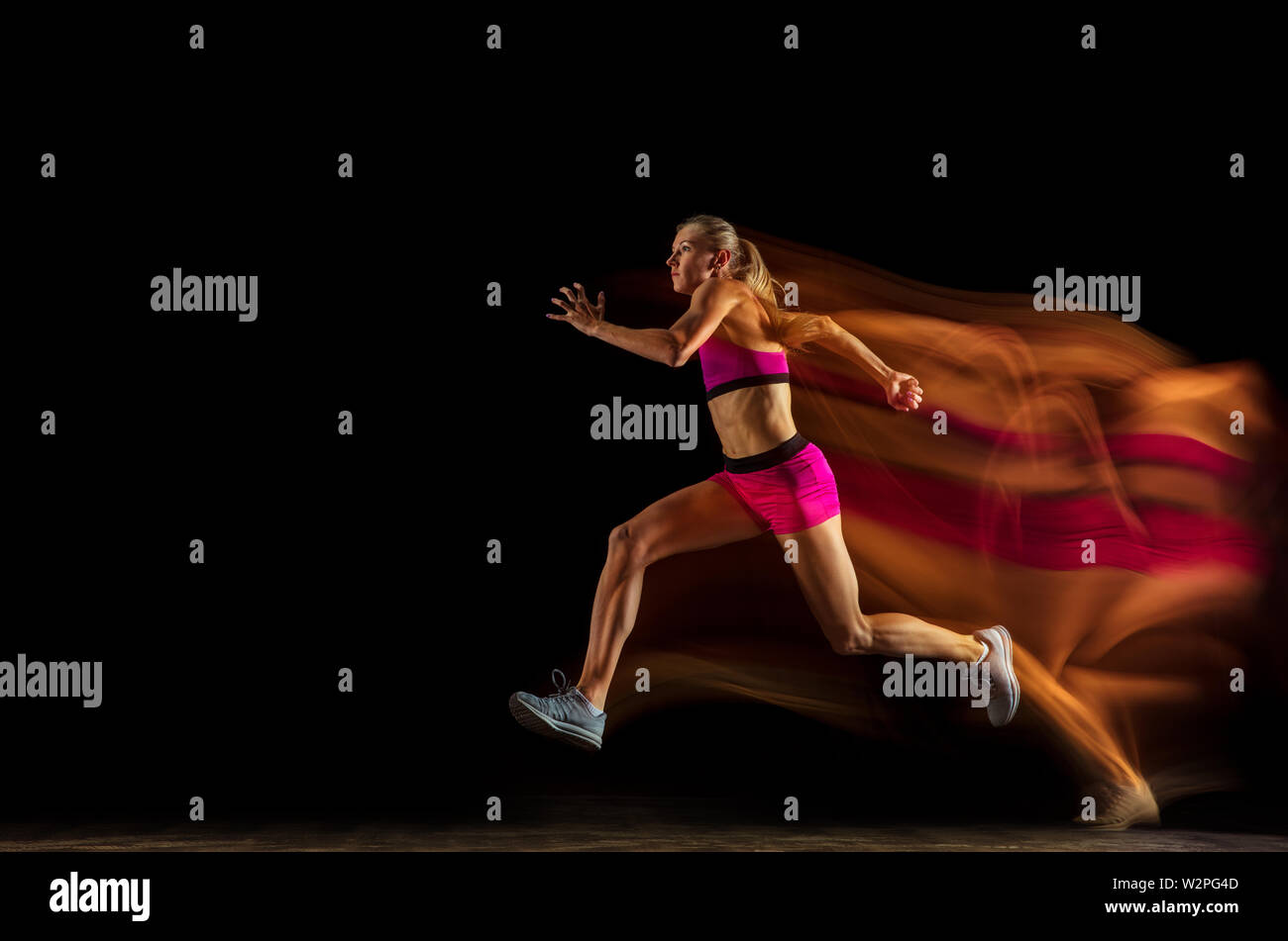 Professional female relay racer training isolated on black studio ...