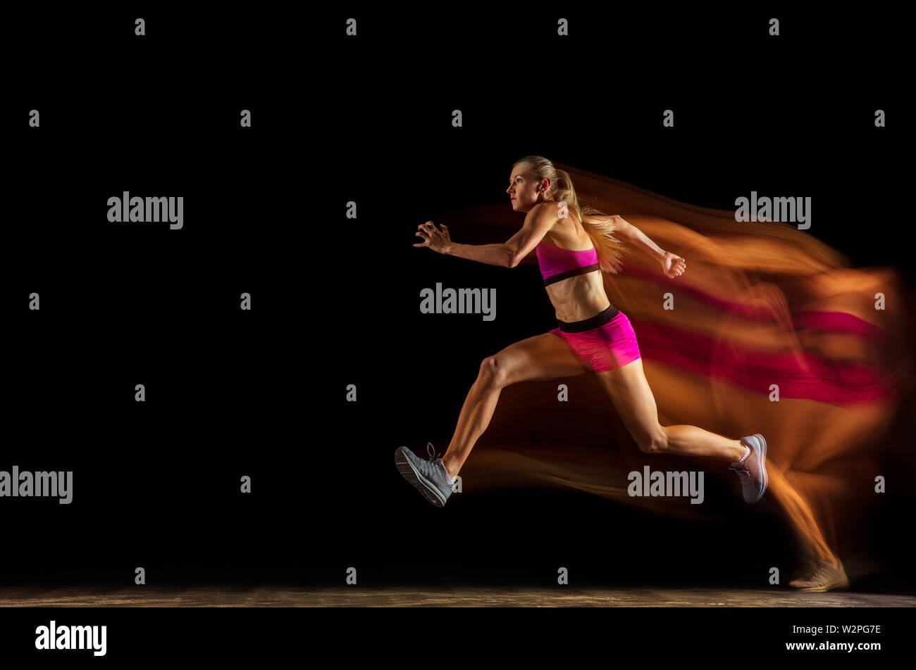 Professional female relay racer training isolated on black studio ...