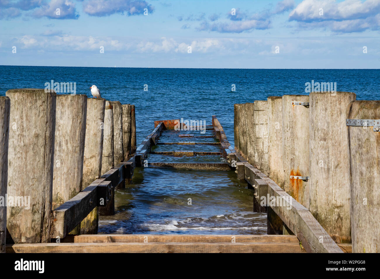 View of the Baltic sea. Old wooden structures at the beach. White ...