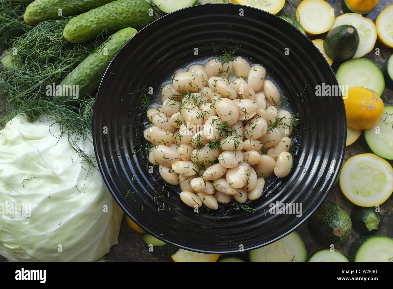 boiled beans in a black plate on the kitchen table Stock Photo - Alamy