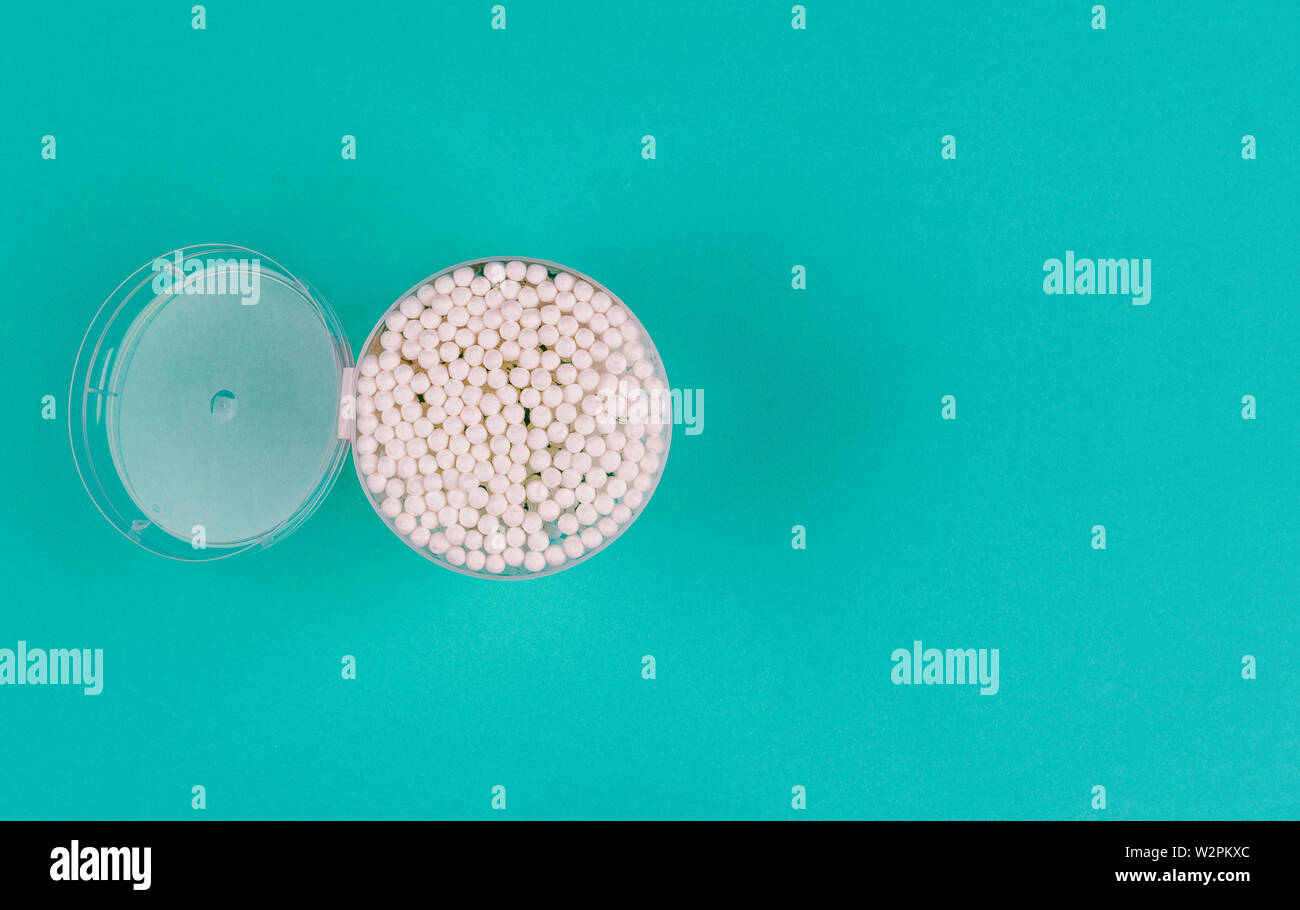 open plastic box with cotton swabs on light blue background top view ...