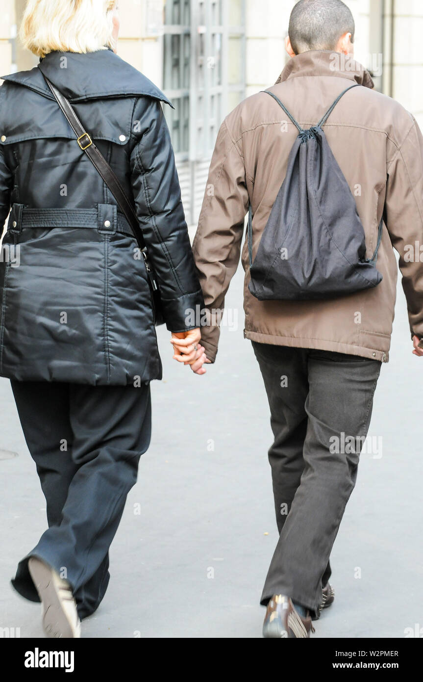 Rear view of a couple walking in the street, Paris, Ile-de-France ...