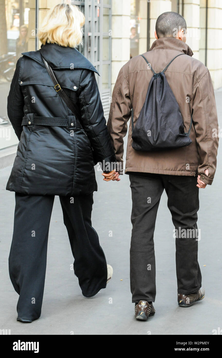 Rear view of a couple walking in the street, Paris, Ile-de-France ...