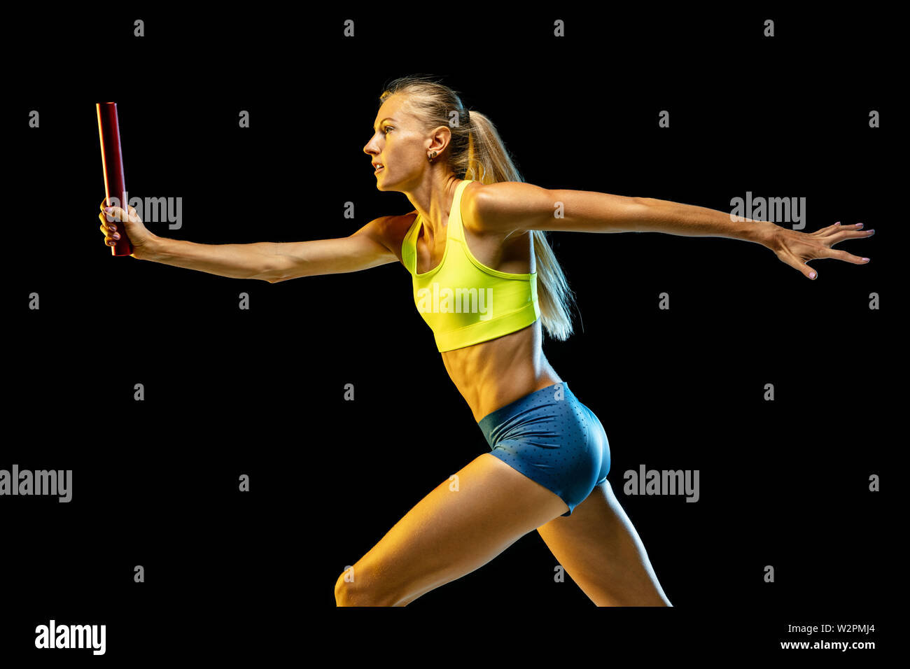 Professional female relay racer training isolated on black studio ...