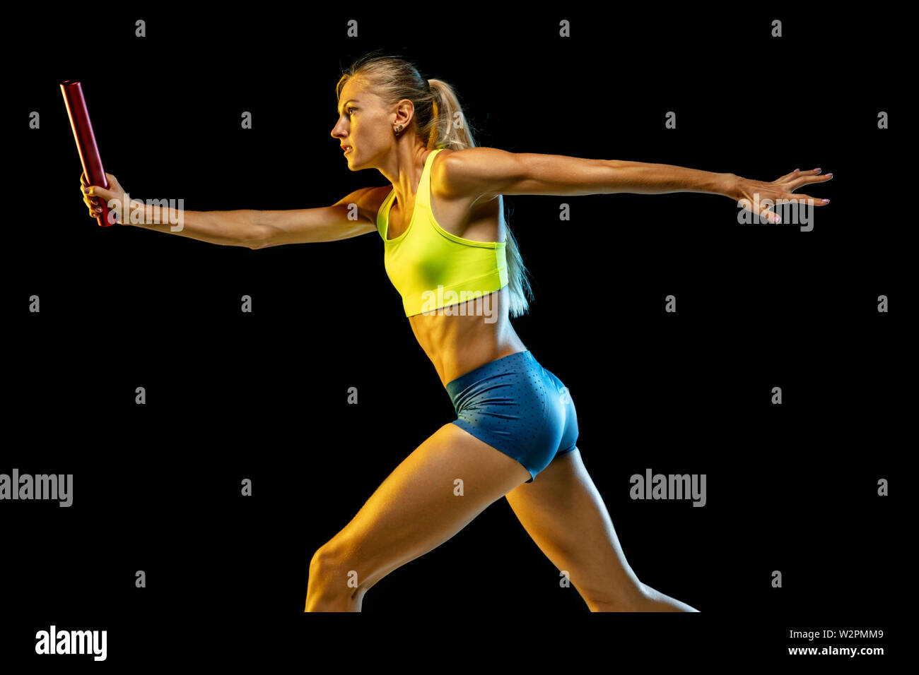 Professional female relay racer training isolated on black studio ...