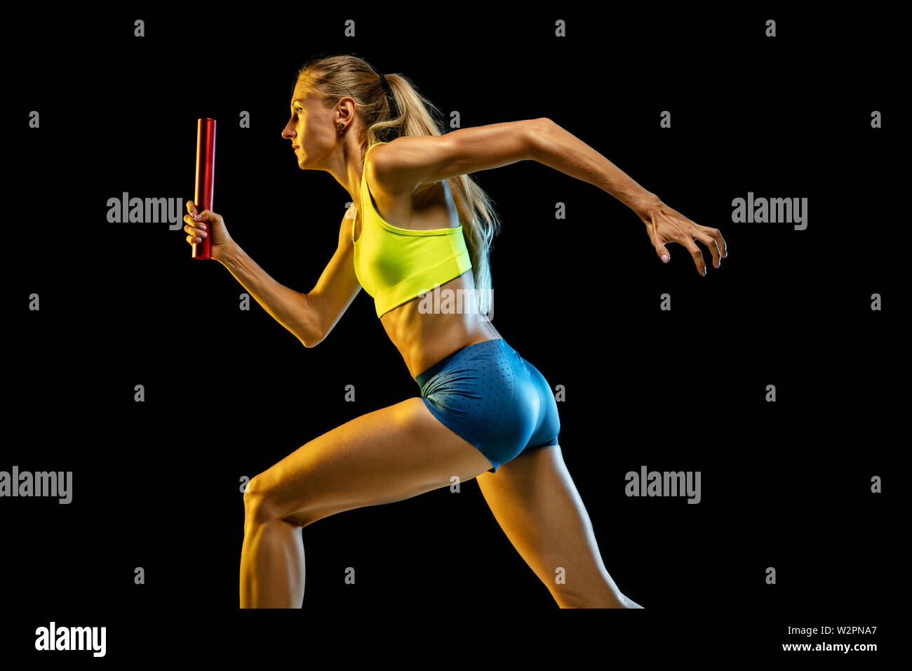Professional female relay racer training isolated on black studio ...