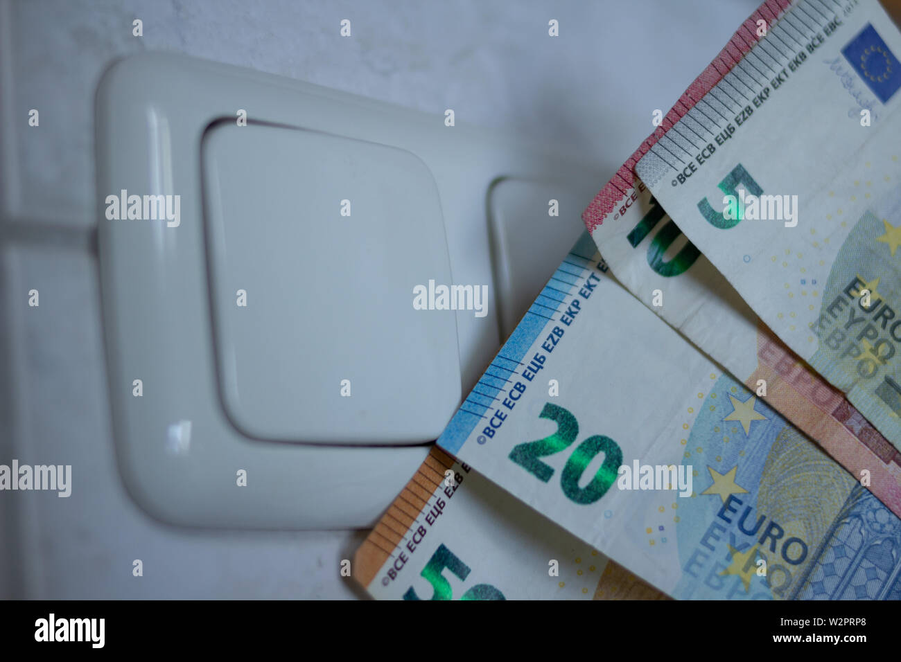 Euro banknotes and an Electric light switch. Expensive green Energy ...