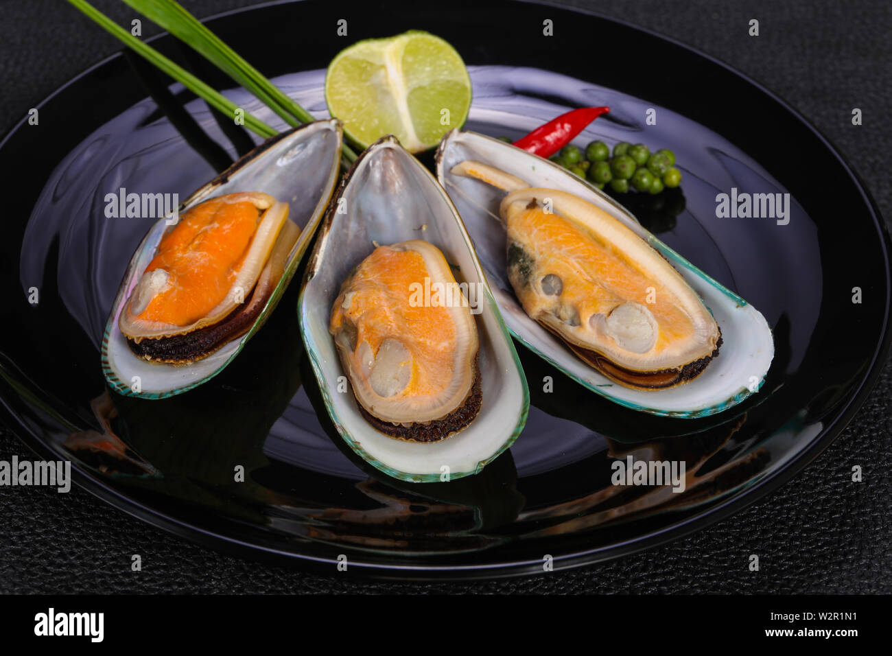Half mussels with lime and green pepper Stock Photo - Alamy