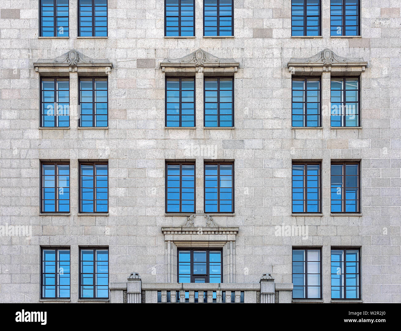 The facade of the city building faced with gray stone. The Windows ...