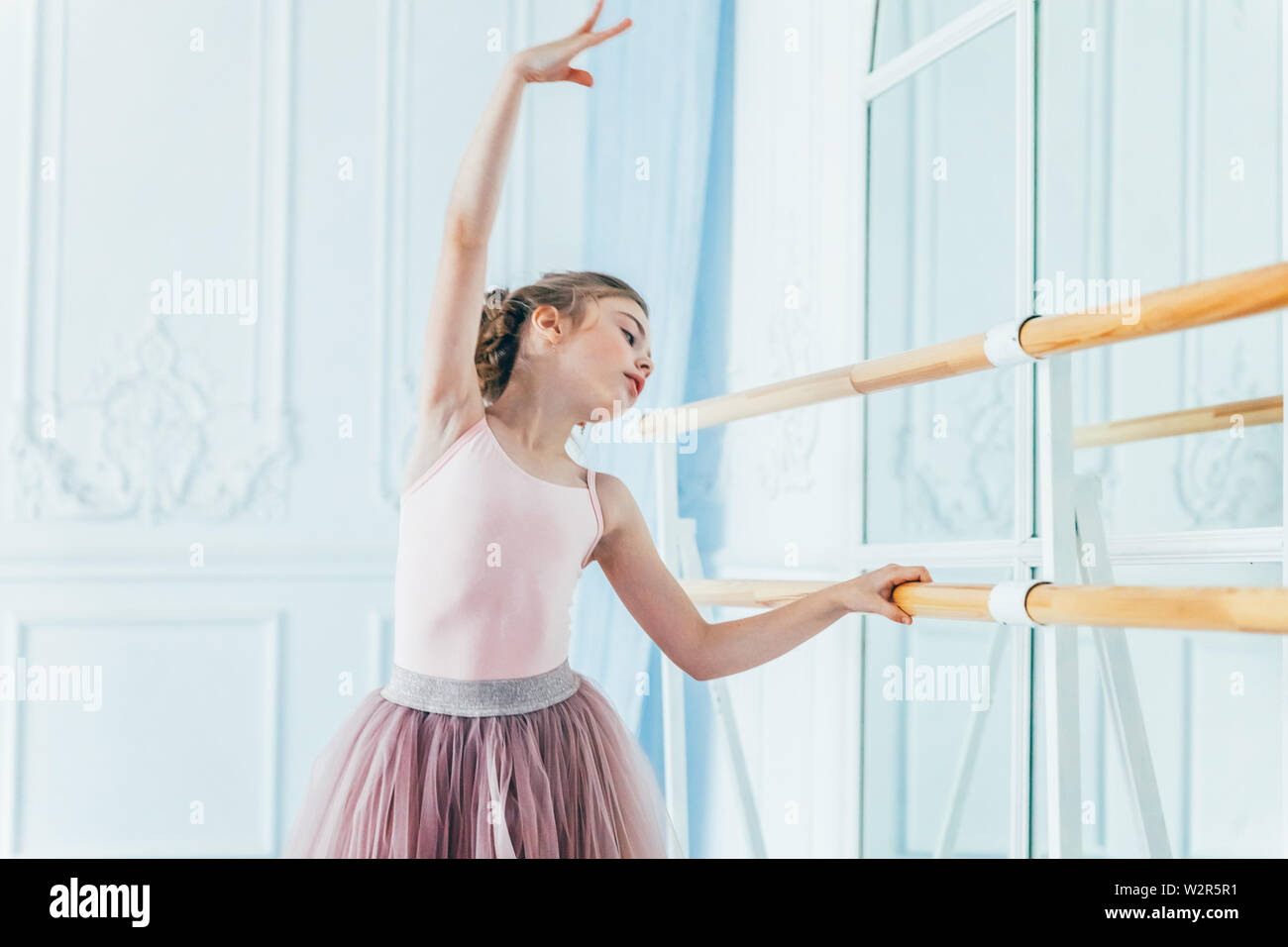 Young classical ballet dancer girl in dance class. Beautiful graceful ballerina practice ballet ...