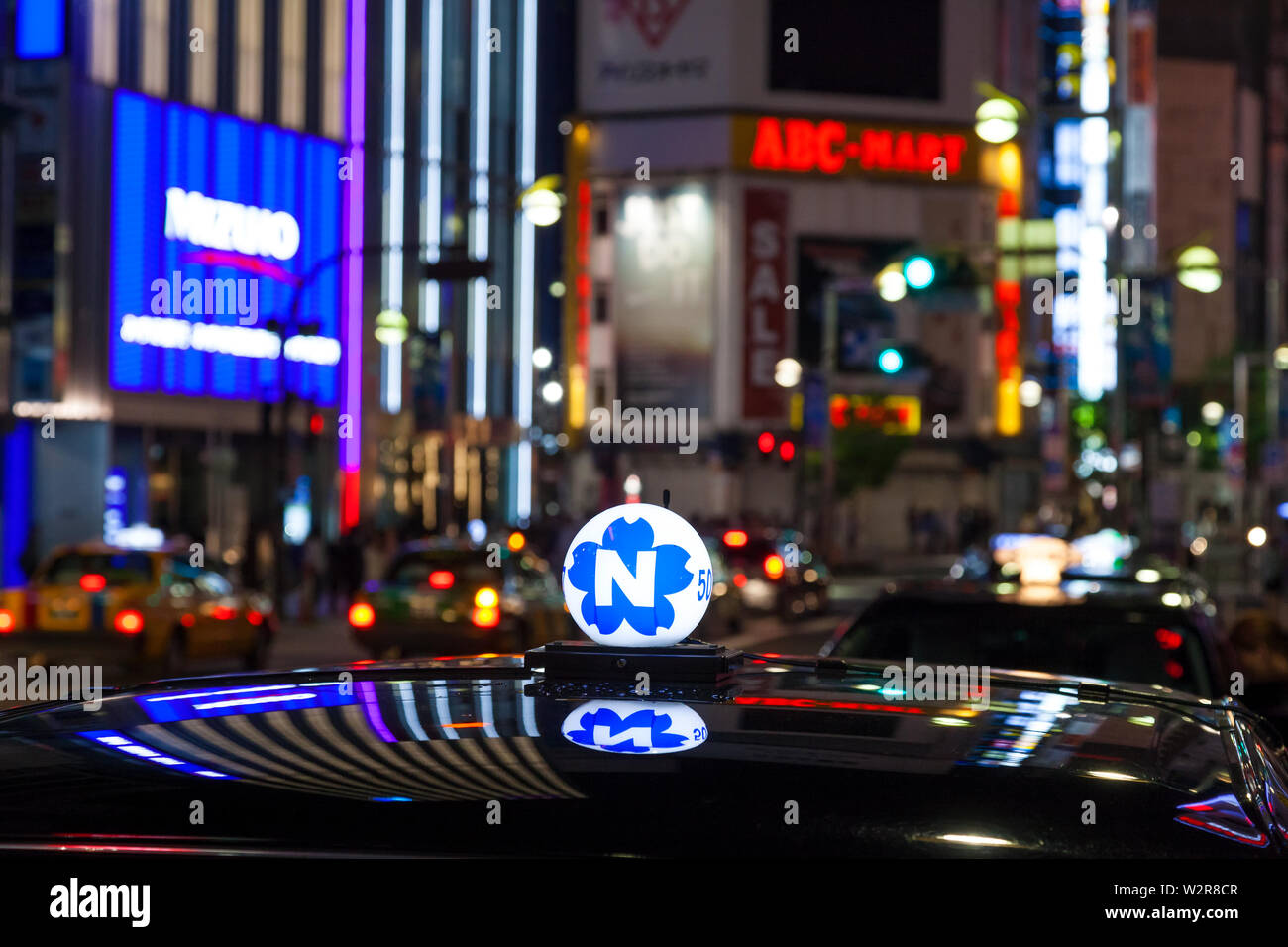 Roof of taxi and neon advertising signs at night in Shinjuku District ...
