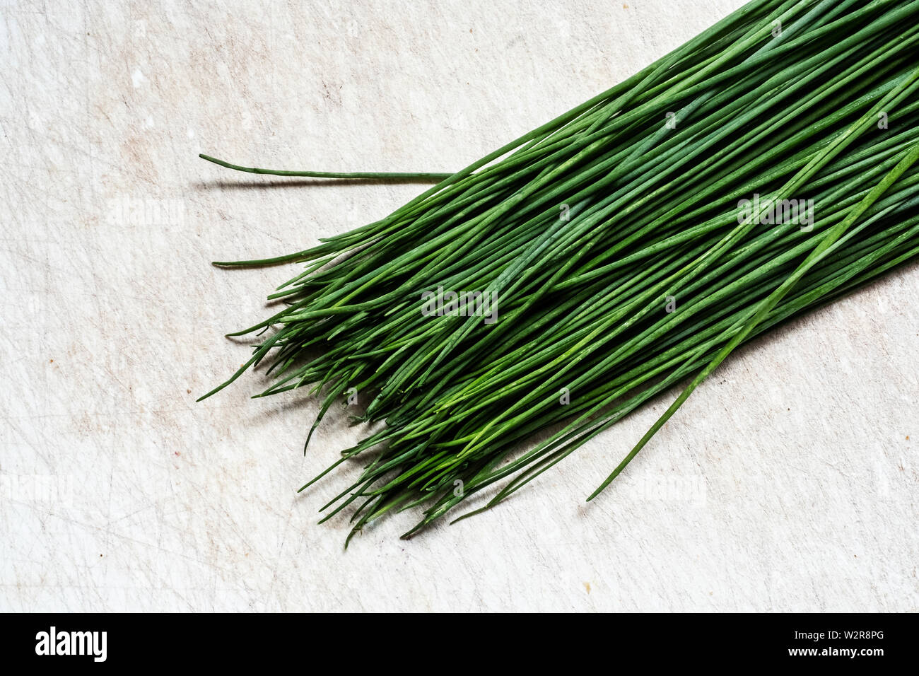 High angle close up of a bunch of fresh chives on white background ...