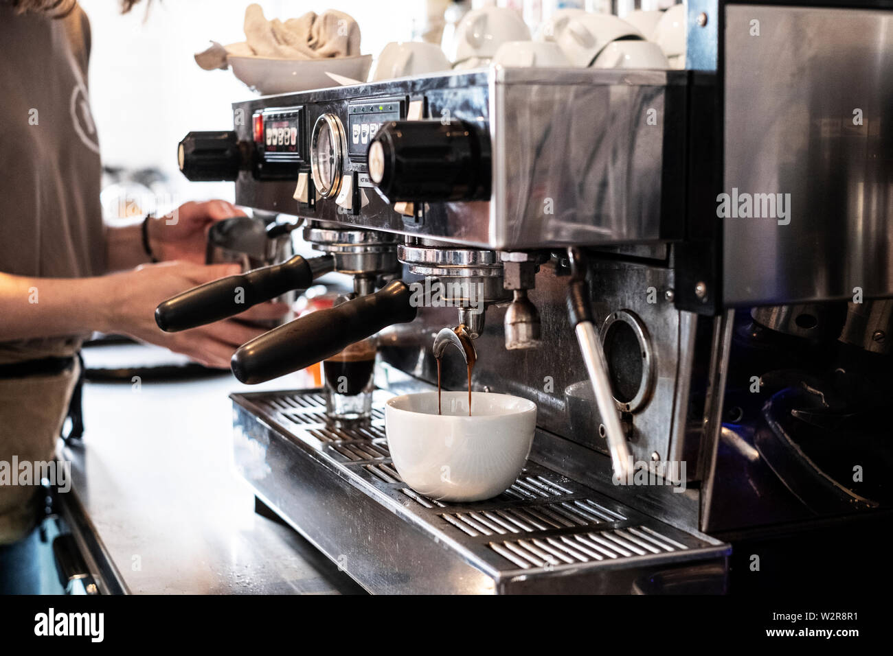 Close up of person making a cappuccino using commercial espresso ...