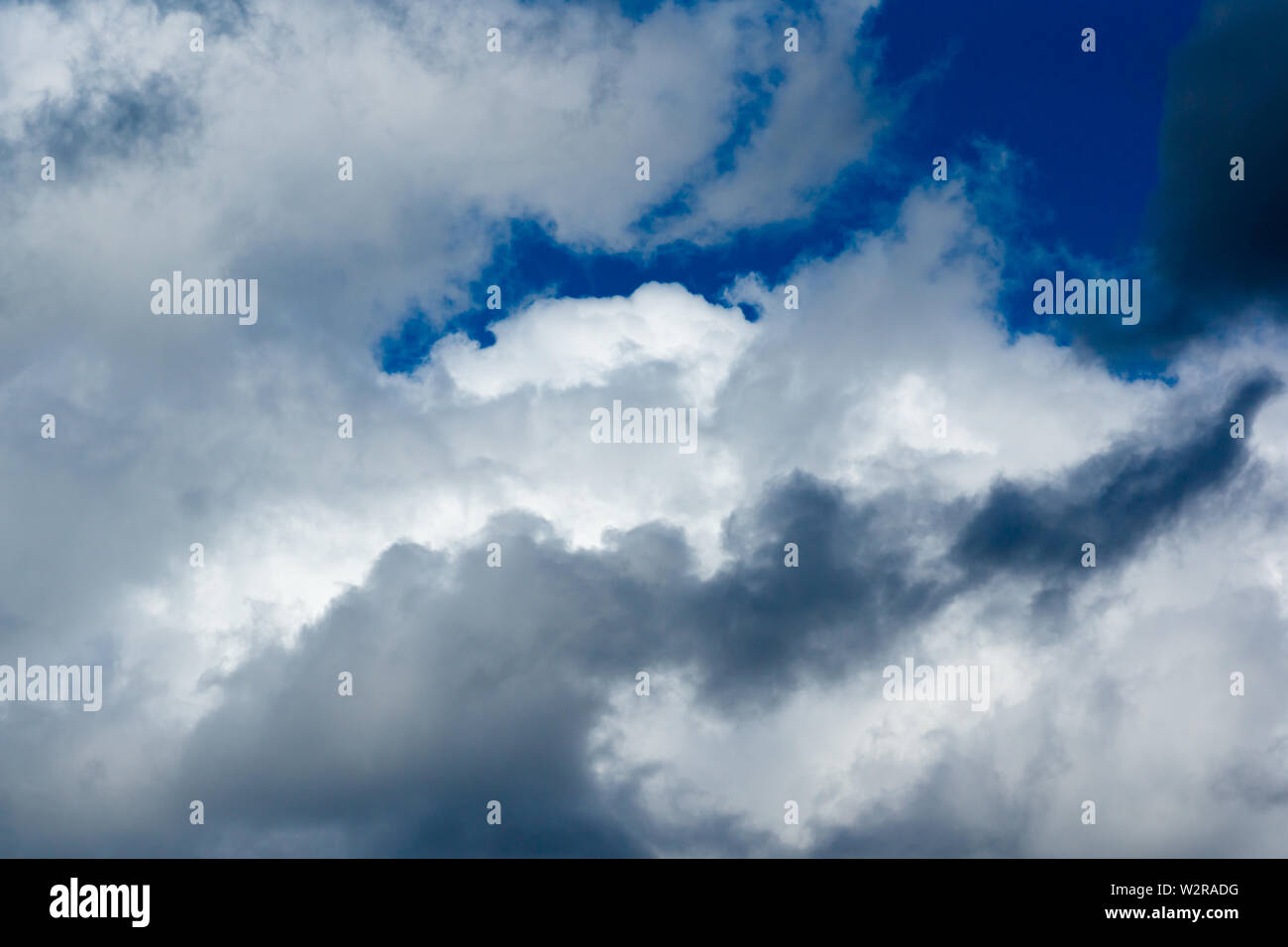 Blue sky with white light clouds in the foreground Stock Photo - Alamy