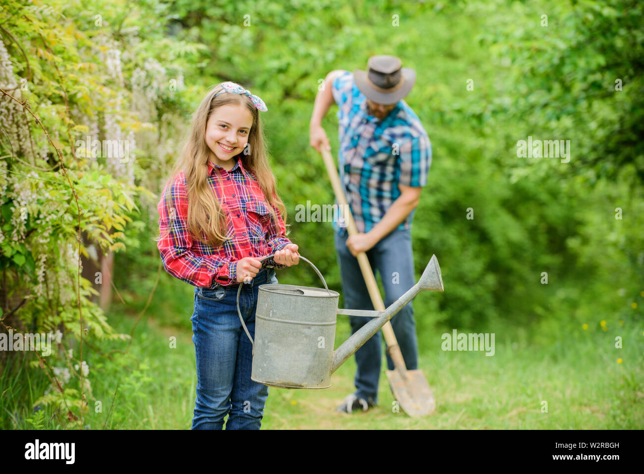 Planting flowers. Family dad and daughter planting plants. Transplanting vegetables from nursery ...