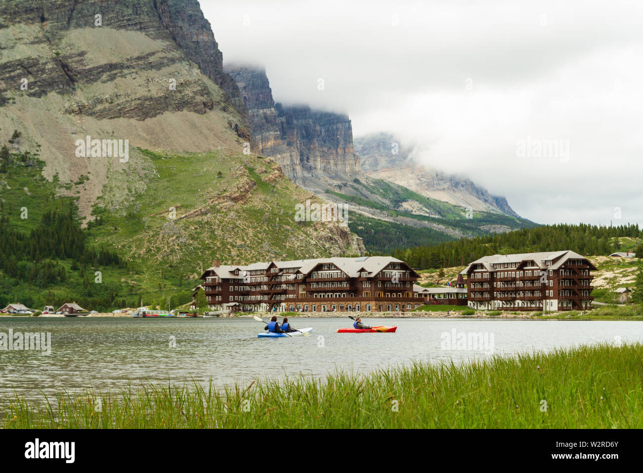Kayakers paddling and bird watching in Swiftcurrent Lake with Many ...