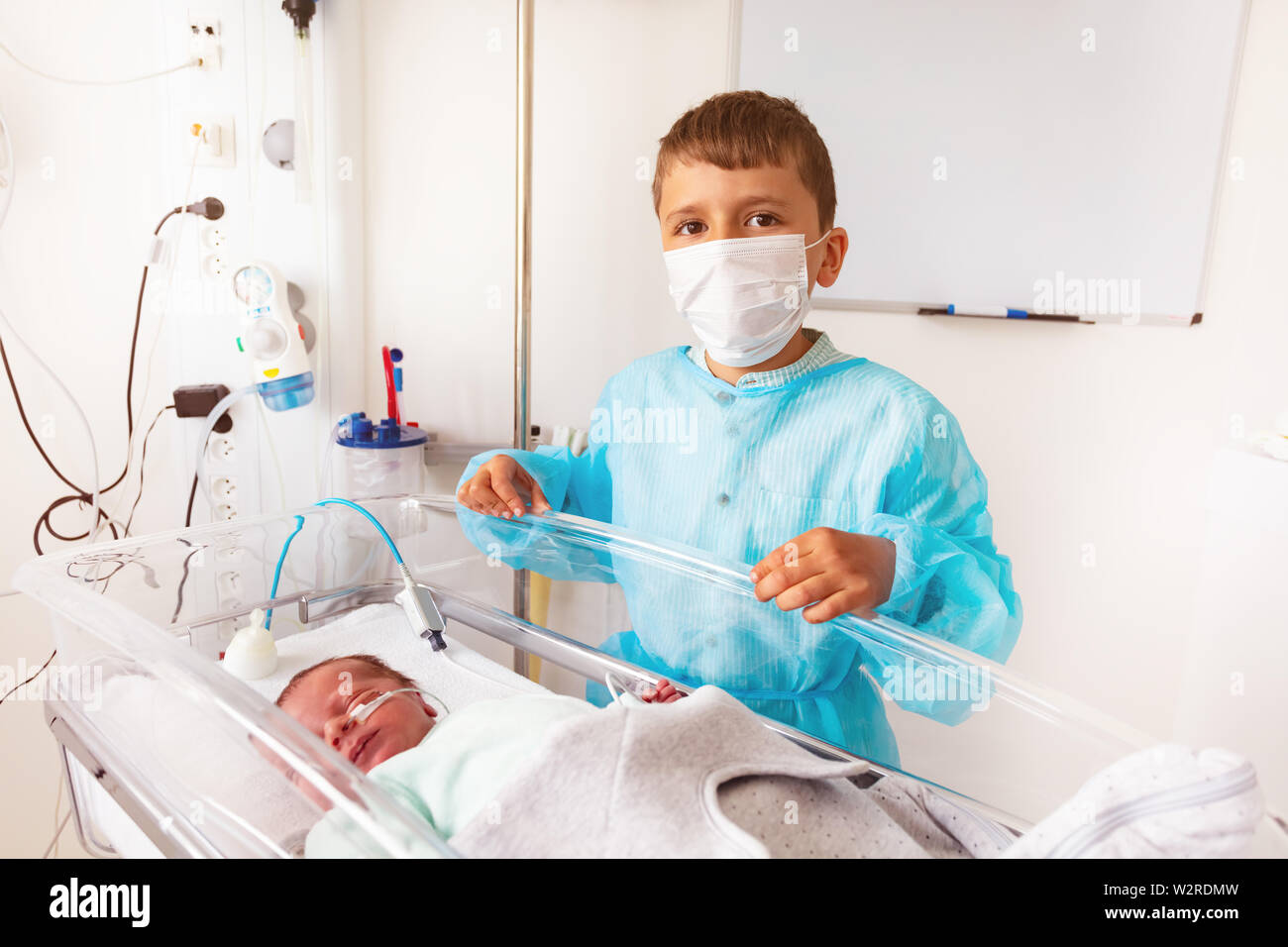 Brother and premature born infant child crib Stock Photo - Alamy