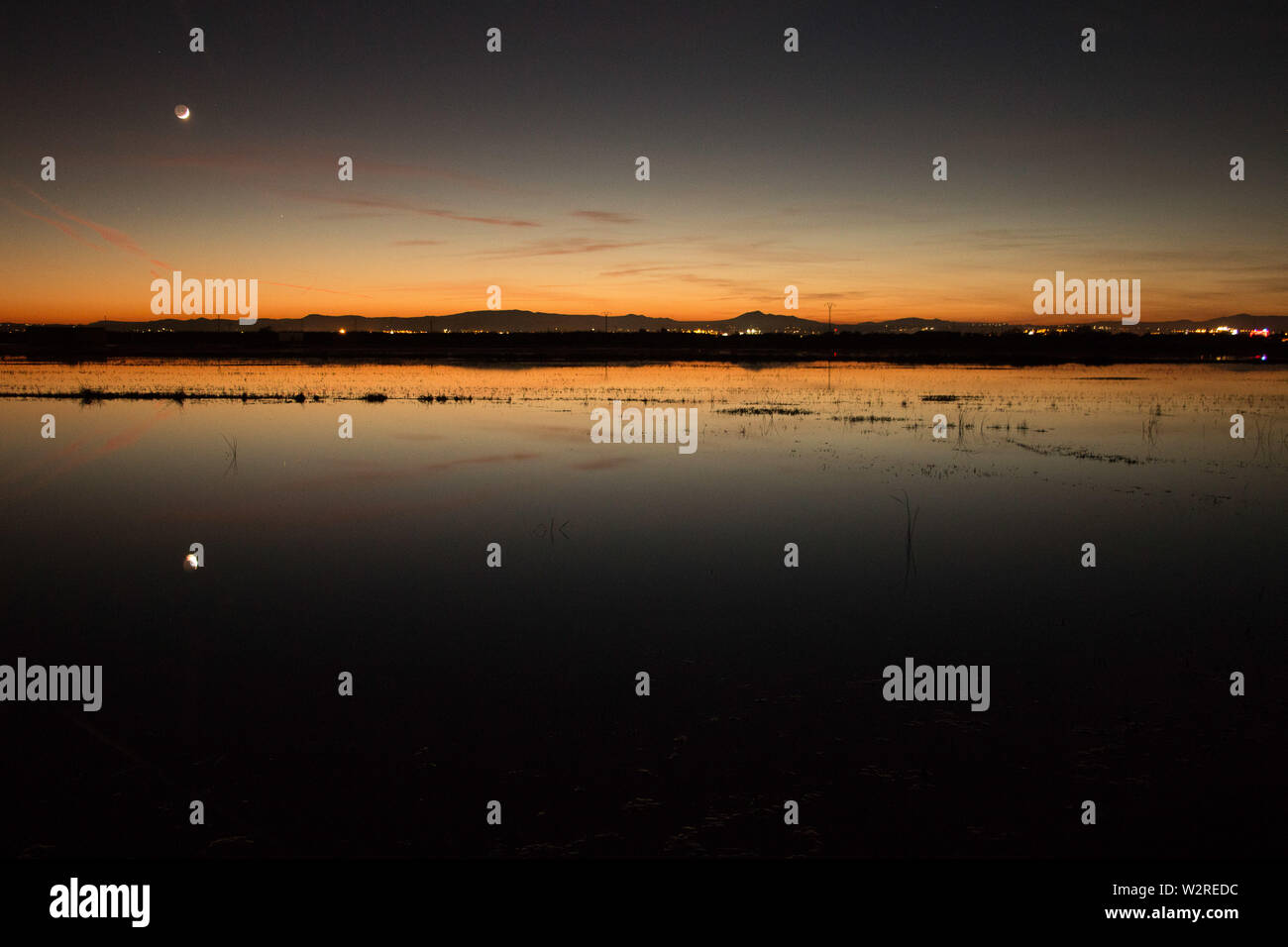 Night landscape in Albufera lagoon, with the moon and its reflection on ...