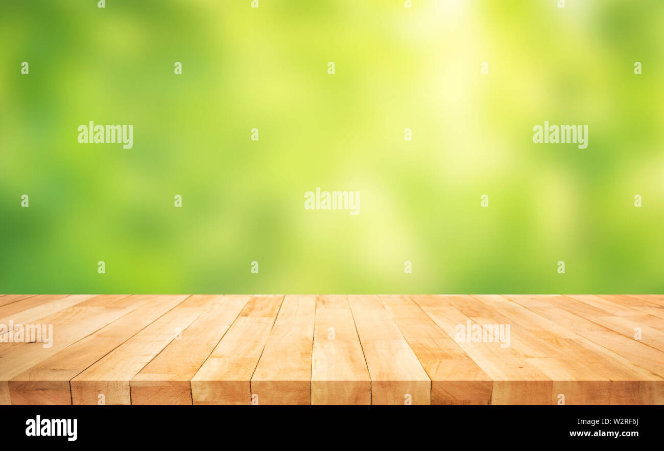 Real wood table top texture on blur fresh green garden background.For ...