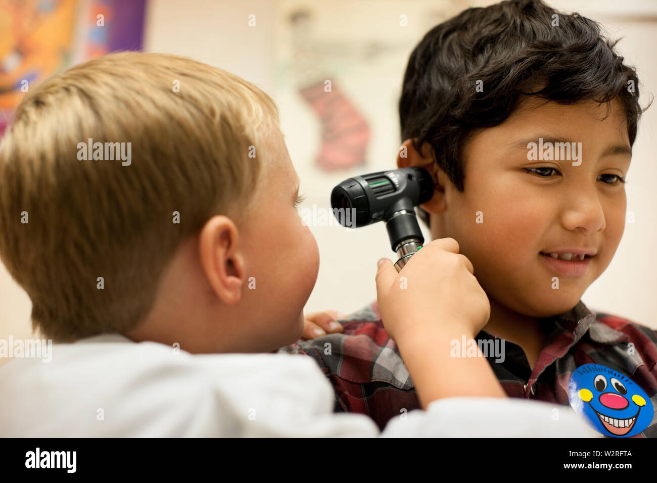 Little boy examining his friend's ear with the otoscope Stock Photo - Alamy