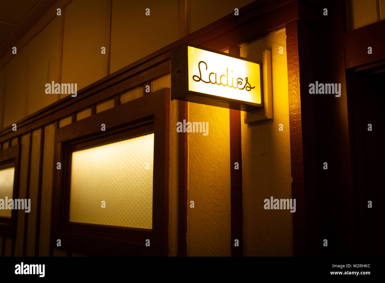 Illuminated Ladies restroom sign in cursive font, Many Glacier Hotel ...