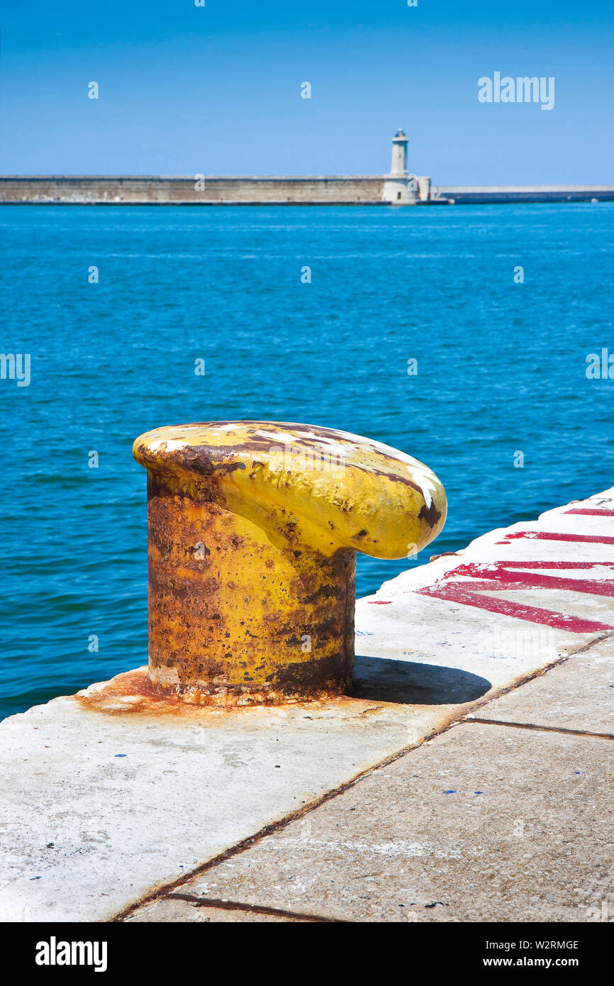 Old rusty yellow cleat for mooring boats Stock Photo - Alamy