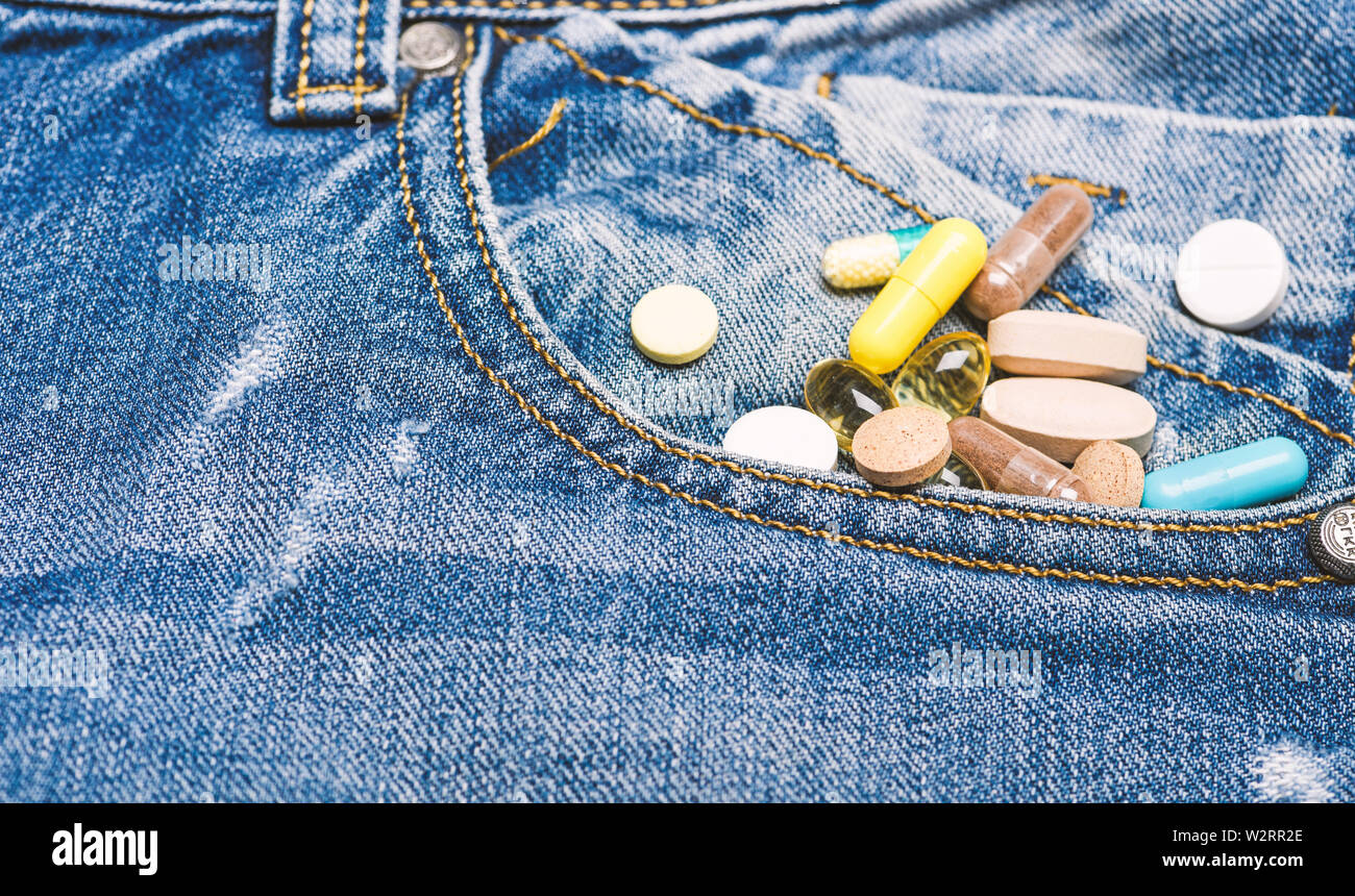 Medicine and treatment concept. Drugs on denim background. Mixing ...