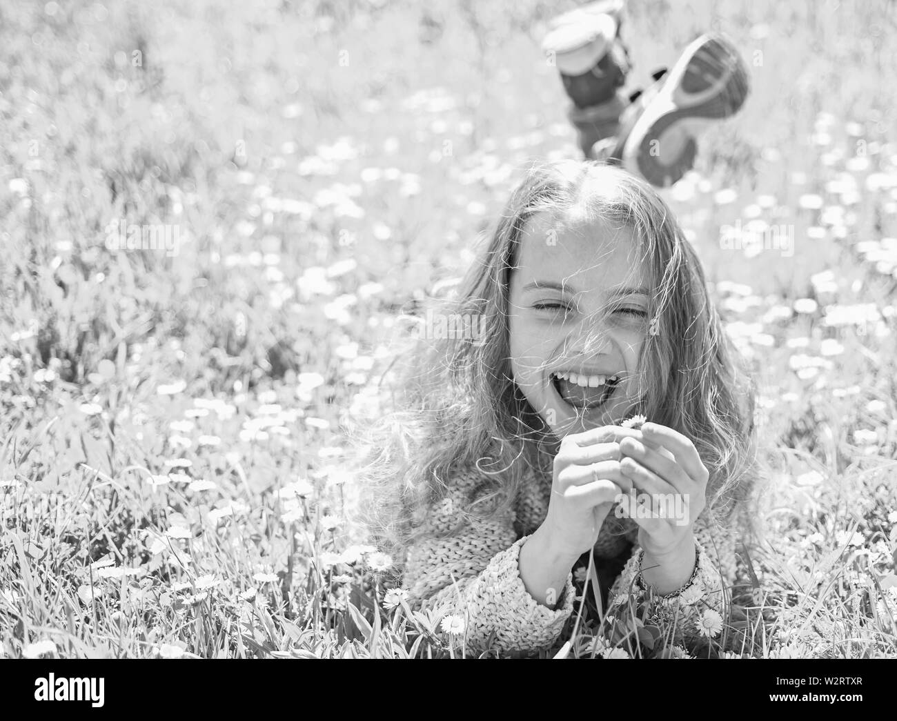 Girl lying on grass, grassplot on background. Child enjoy spring sunny ...