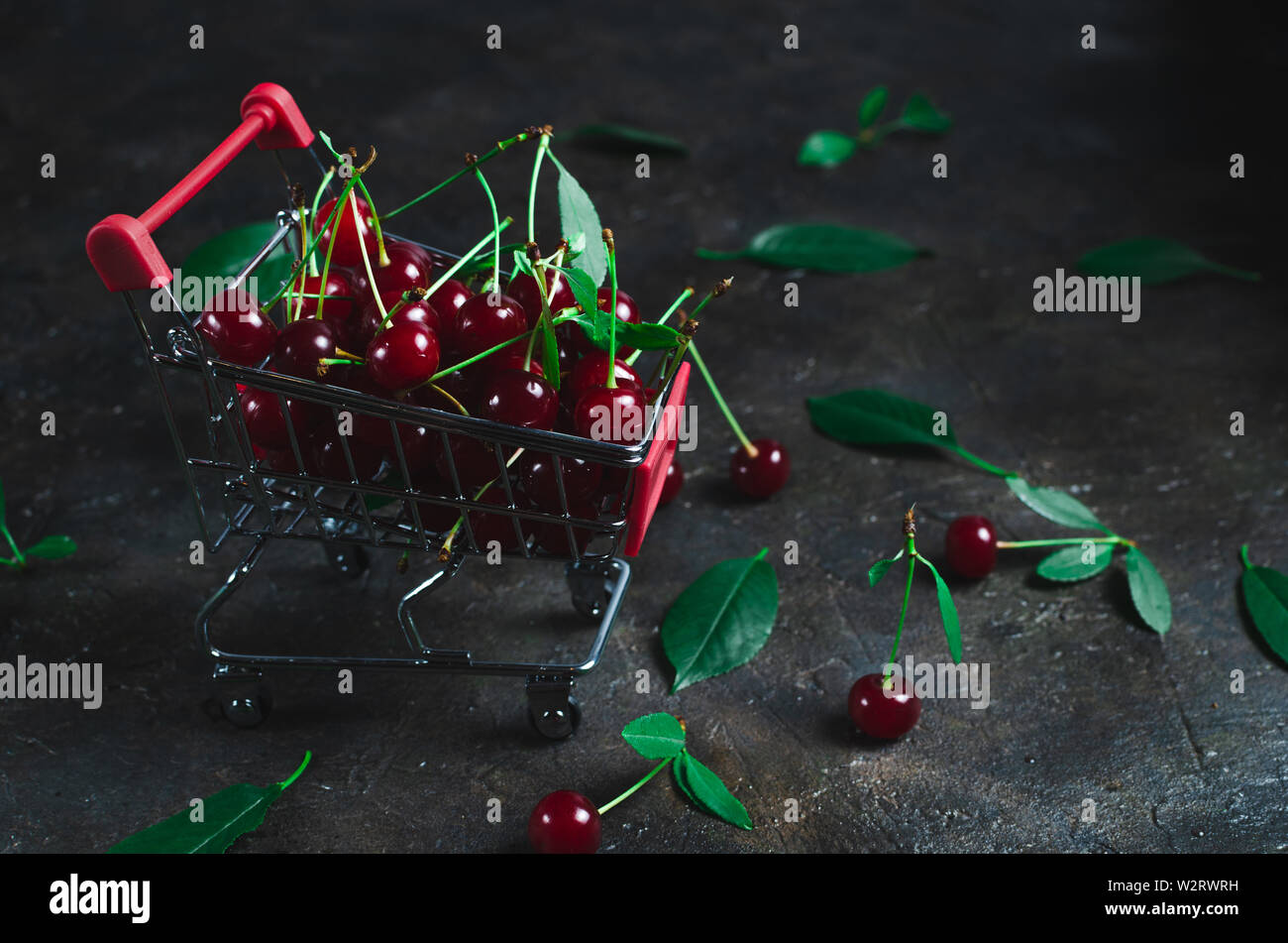 Bright red cherry in a shopping cart on an old concrete floor Stock ...