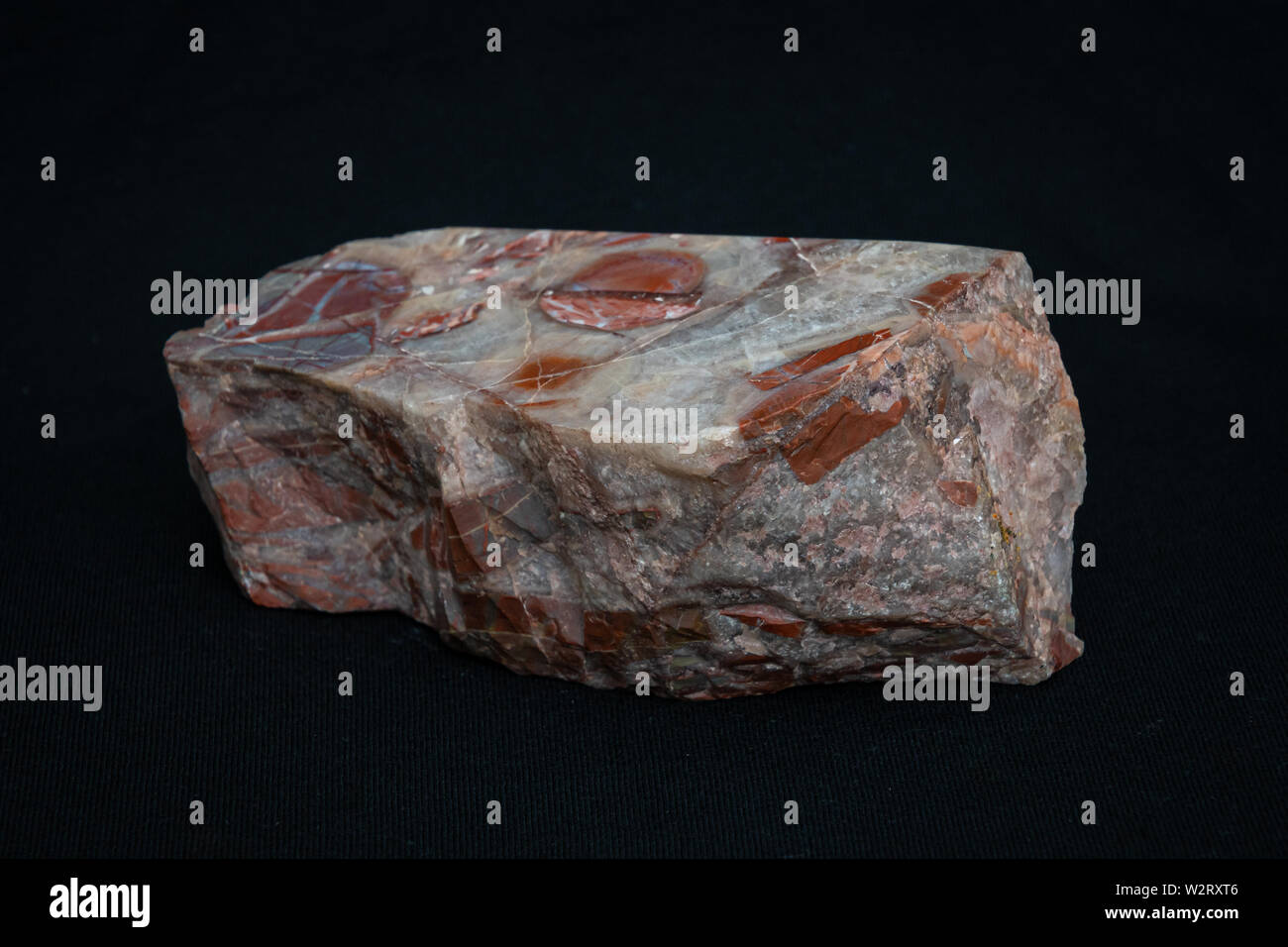 Red gemstone with colorful structure in many tones formed under high ...