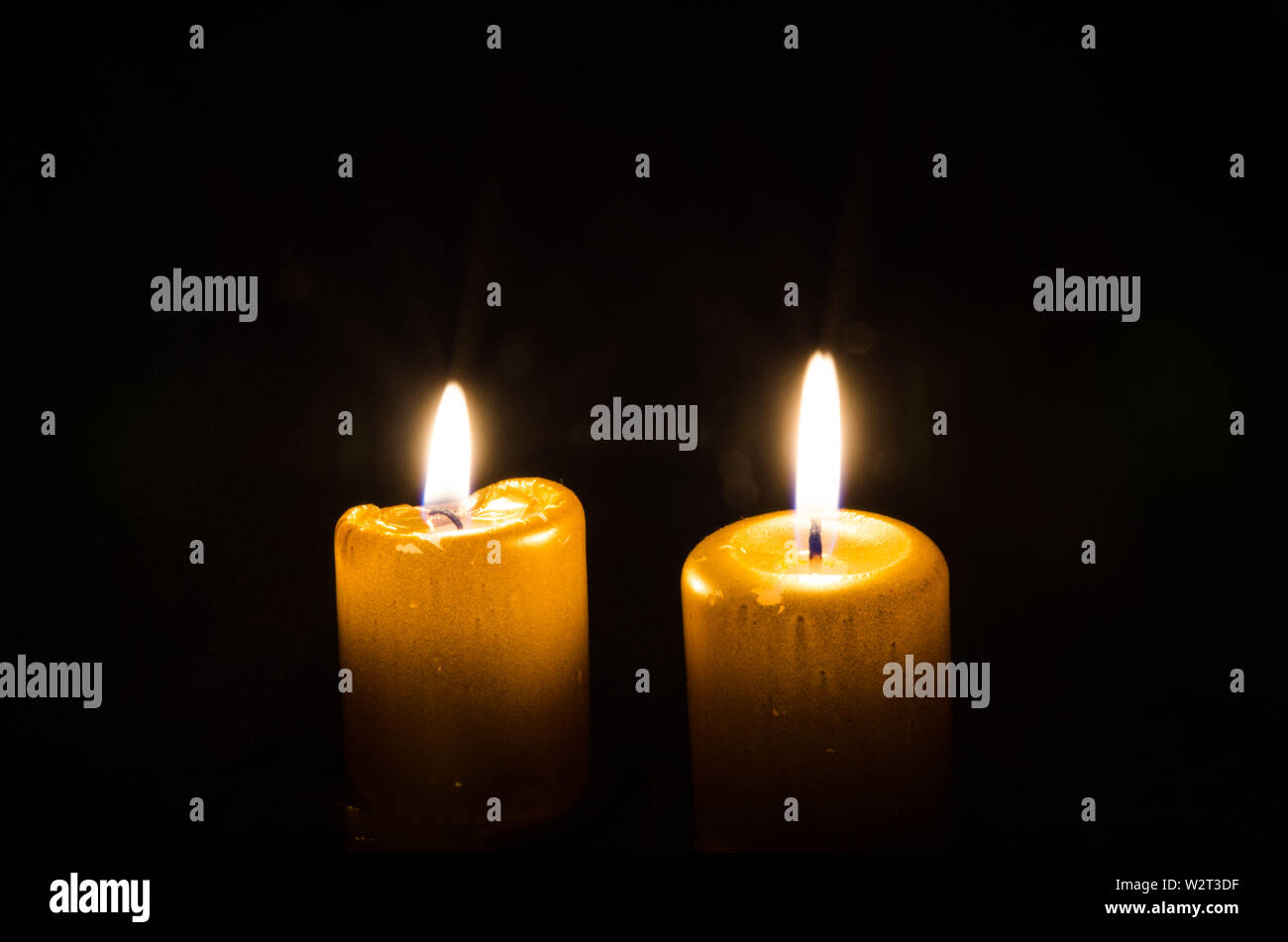 two burning candles over dark background Stock Photo - Alamy
