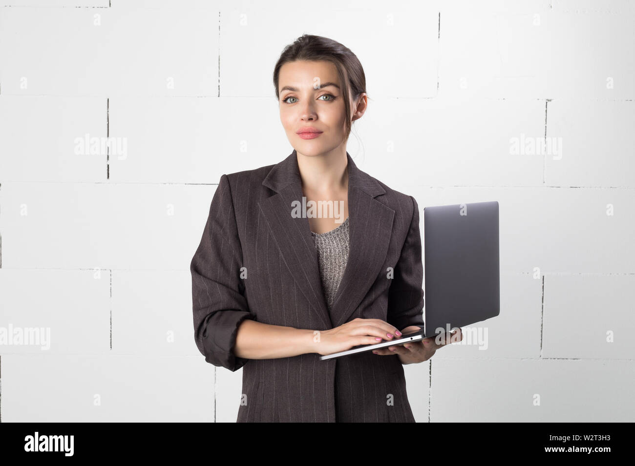 Business woman in suit with a laptop in hand on white background Stock ...