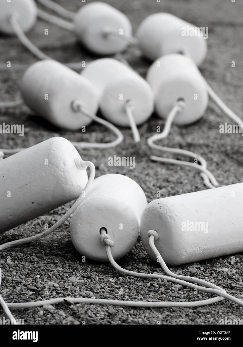 Floating buoys on ropes lined on the coast beach and ready to be put in ...