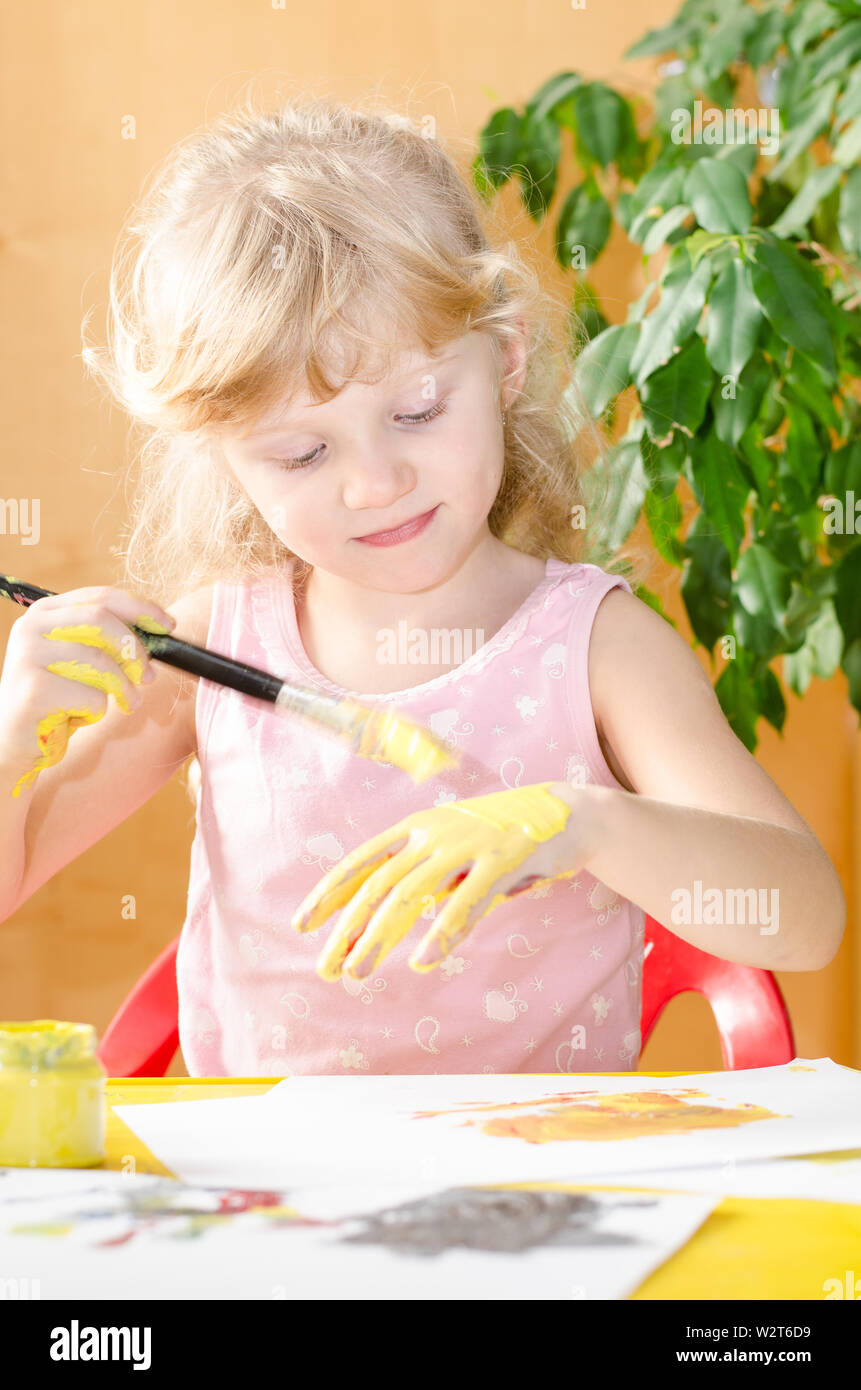 smiling blond girl painting with brush Stock Photo - Alamy