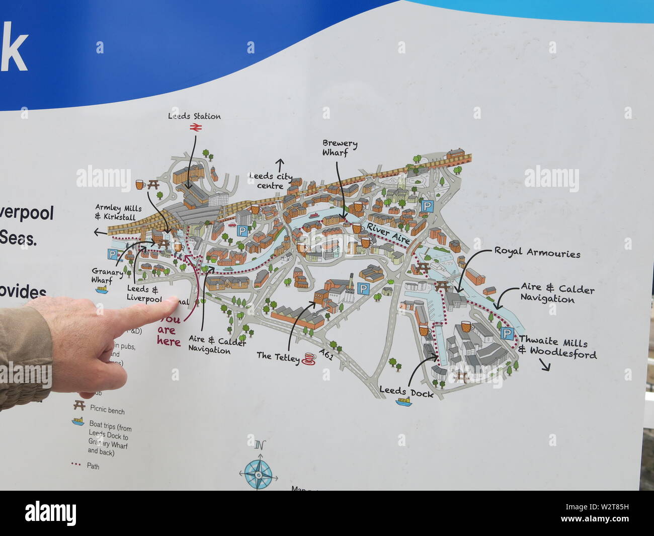 A tourist's finger points out where he is on the street map of the ...