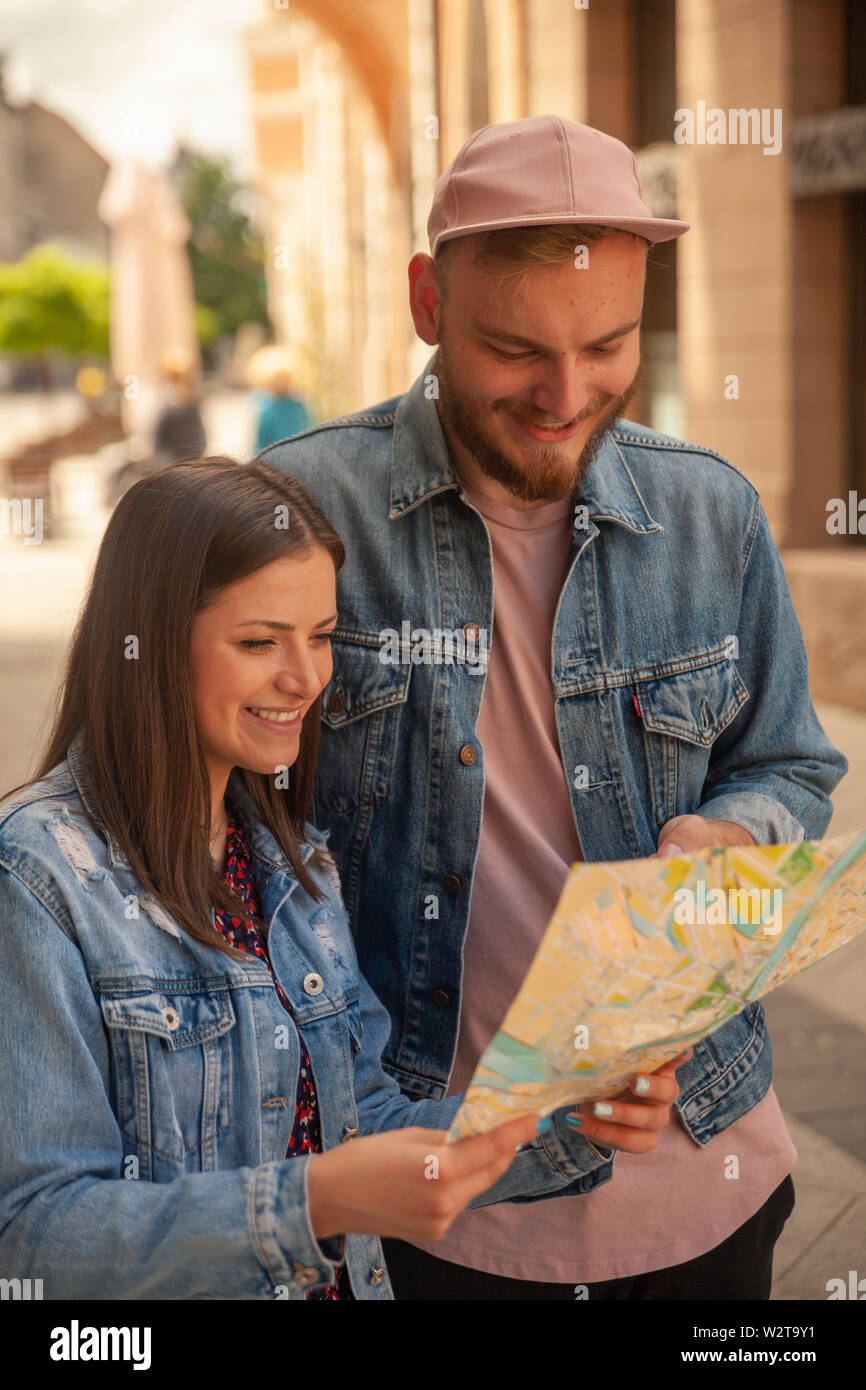 two hipsters looking at a city map Stock Photo - Alamy