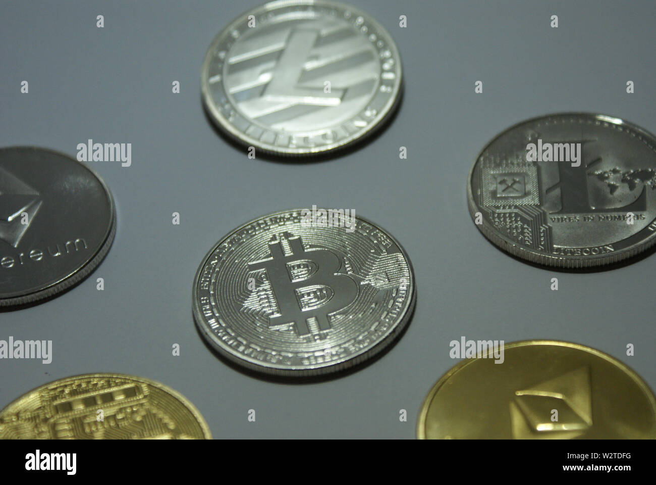 collection of silver and gold cryptocurrency coins on a white ...