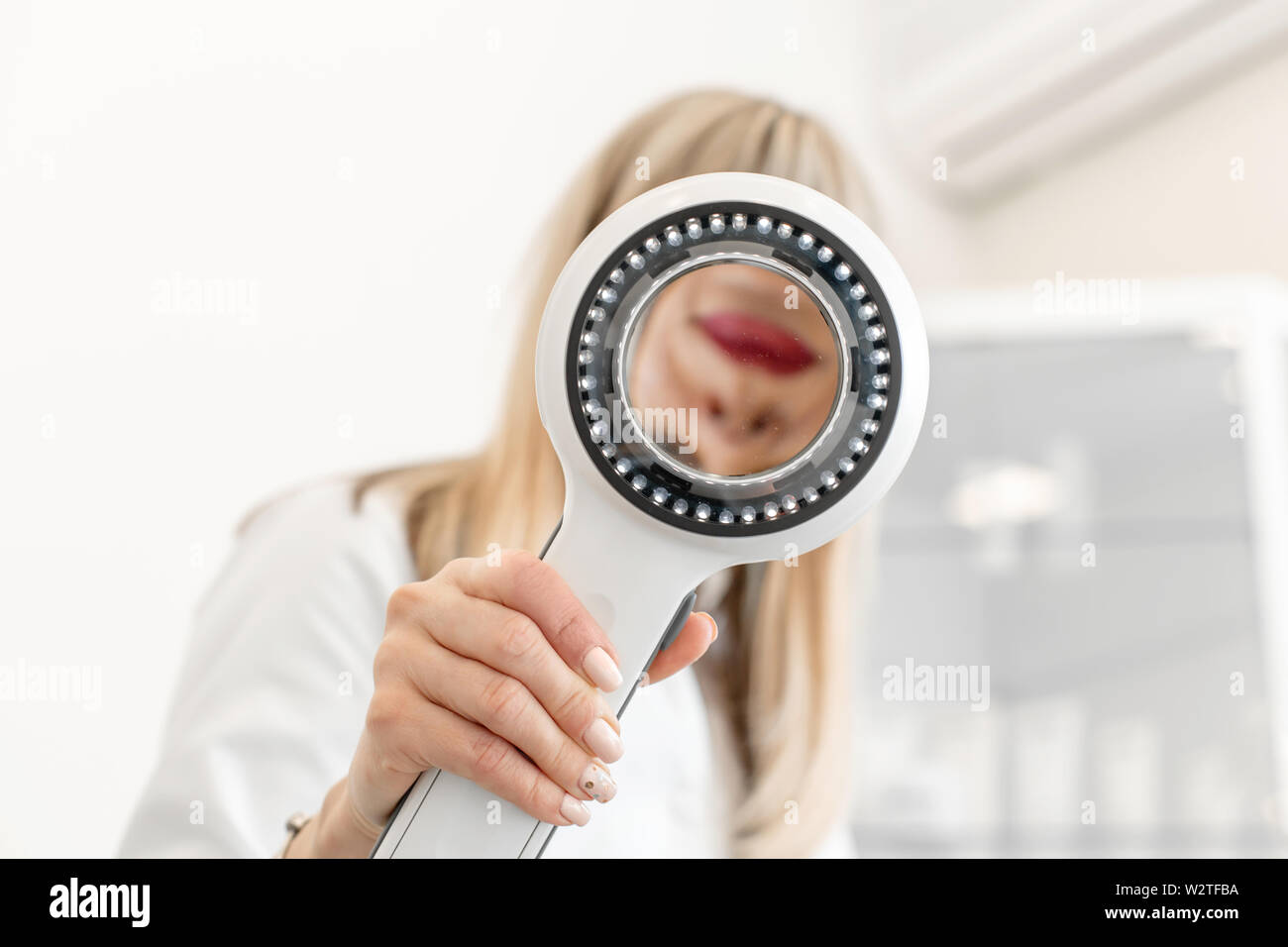 The doctor trichologist dermatologist examines the camera through the ...