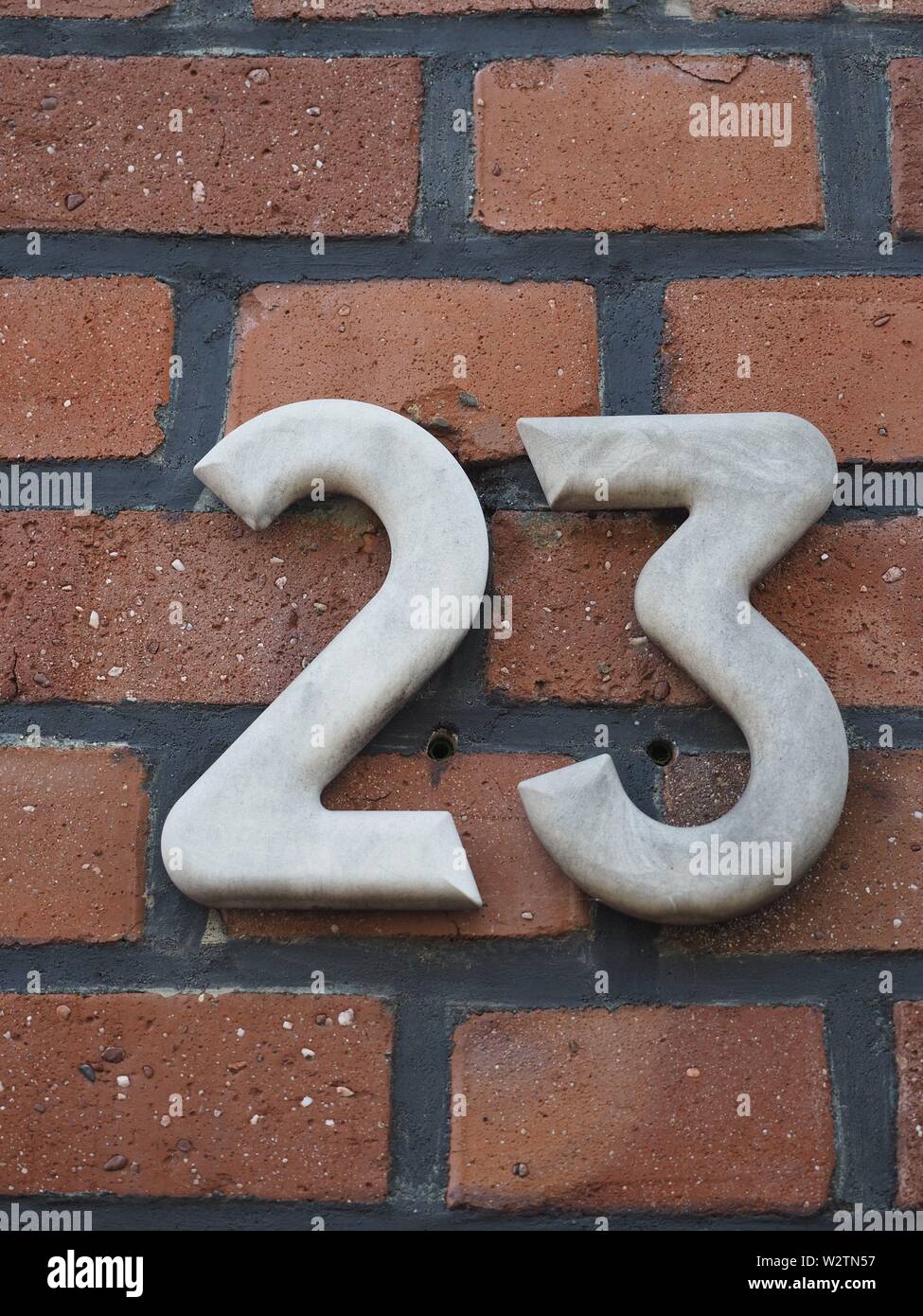 House number 23, white numbers on a clinker wall Stock Photo - Alamy