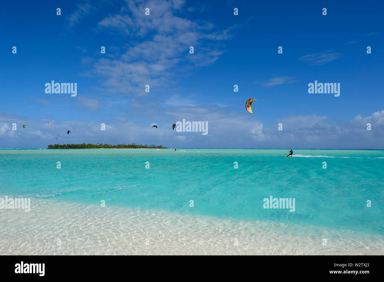 Tourists kitesurfing on the turquoise lagoon of Aitutaki, Cook Islands ...