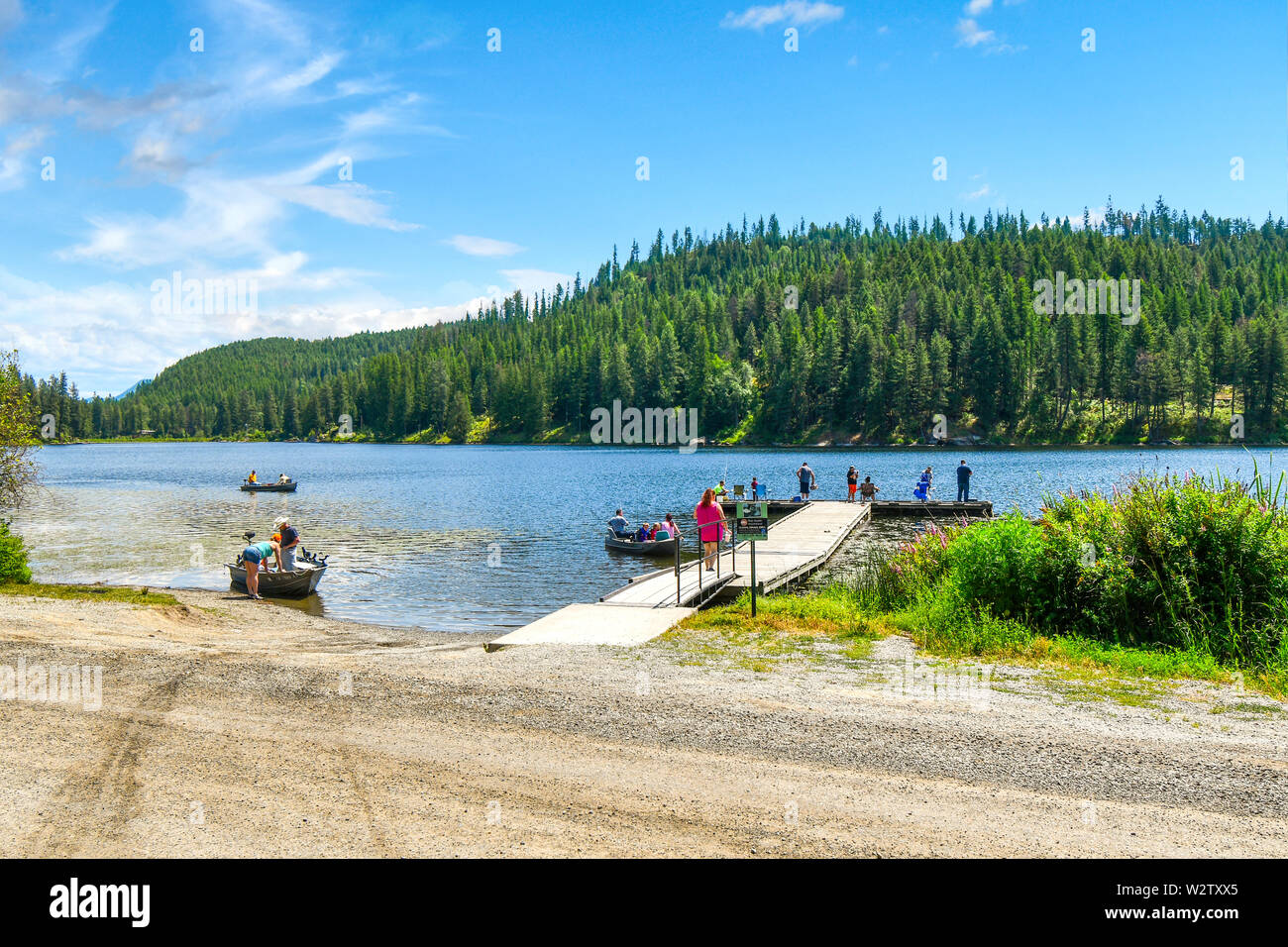 Families and friends gather at a small wooden boat ramp on Granite Lake ...