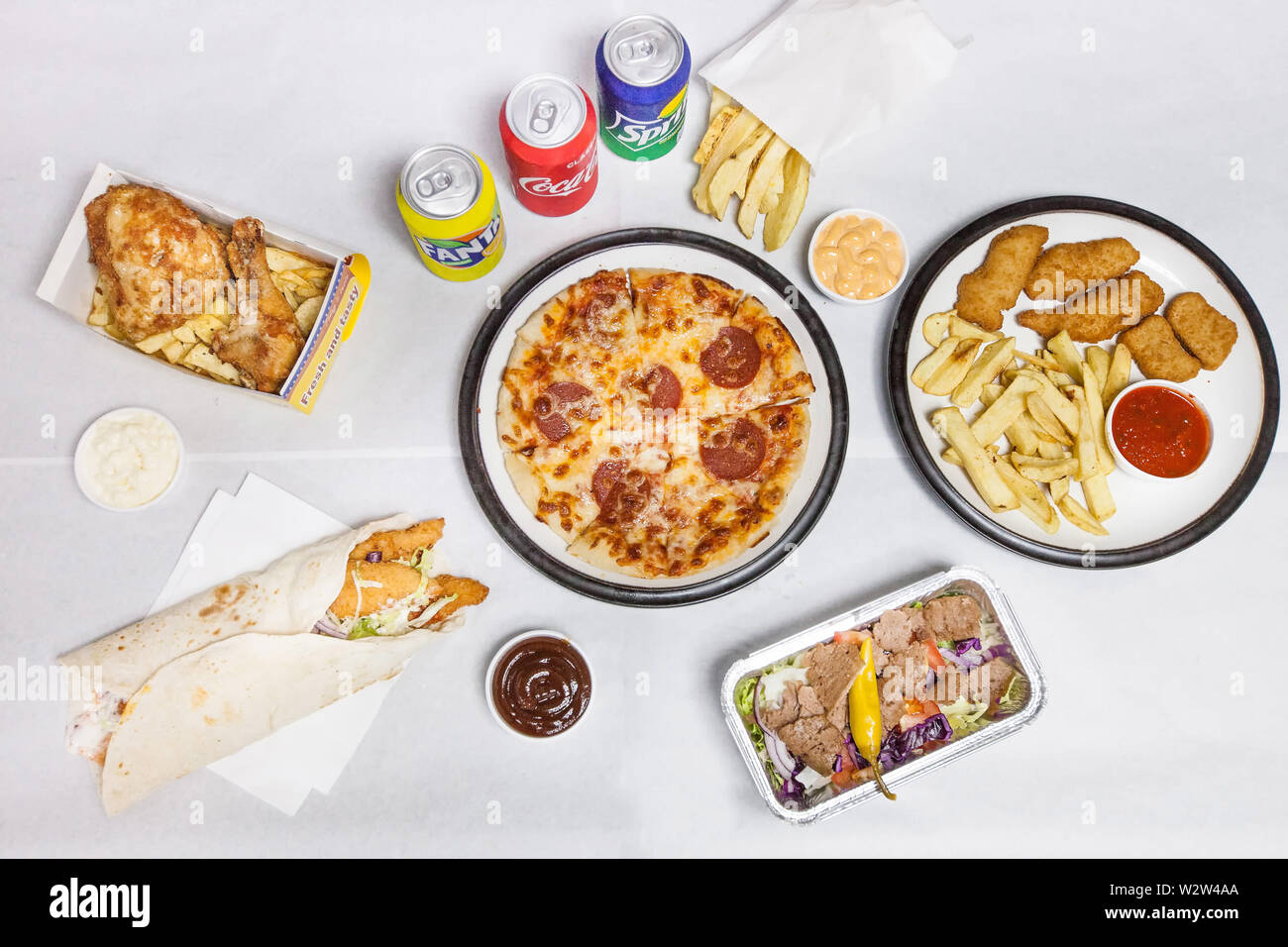 Selection of unhealthy take way fast-food presented on table covered ...