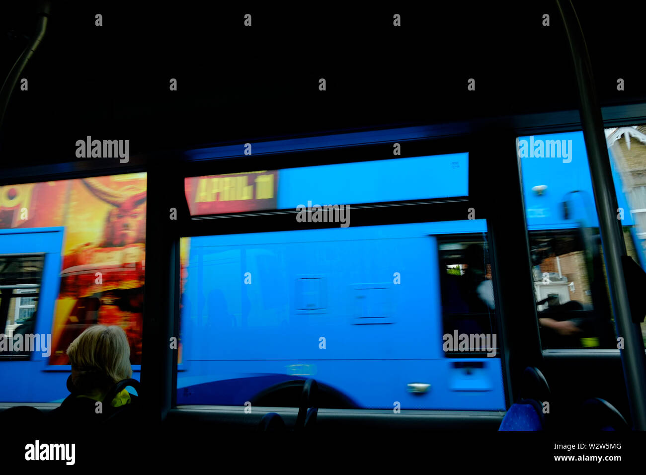 View from a bus seat out the bus window as two buses pass each other ...