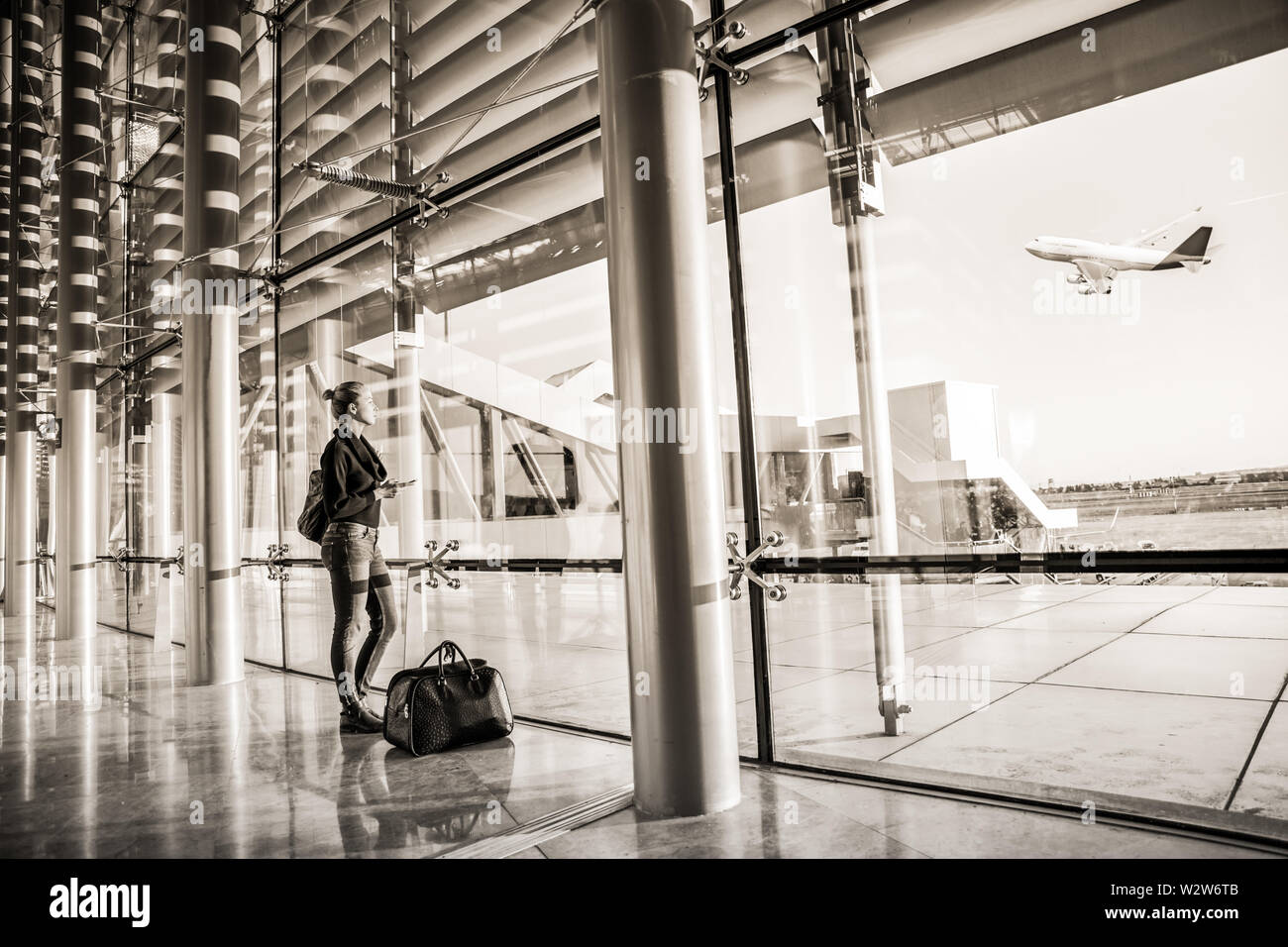 Young woman waiting at airport, looking through the gate window Stock ...