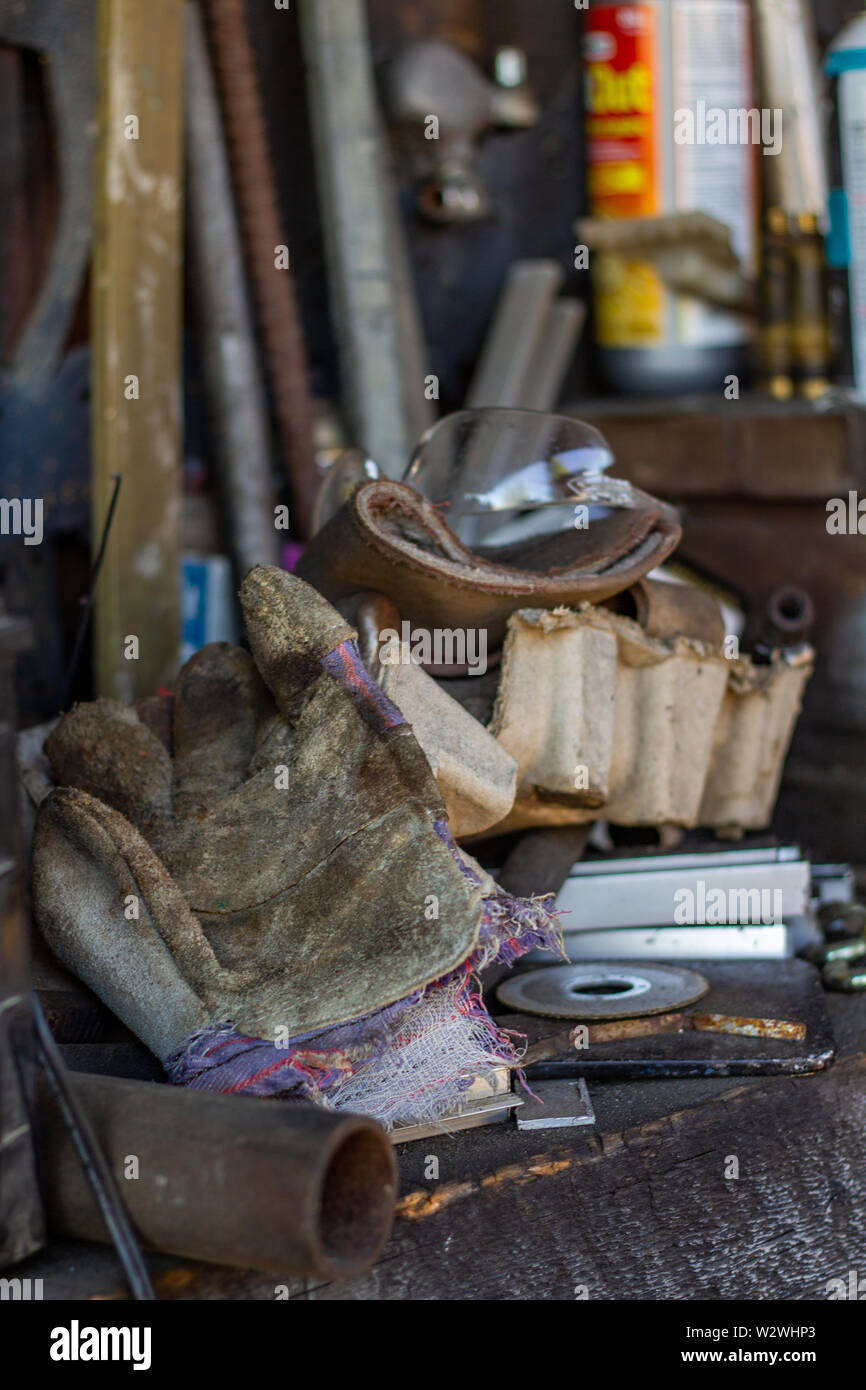 Pile of tools, scraps and gears on a work bench Stock Photo - Alamy