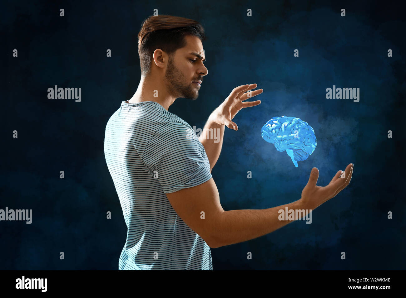 Handsome man with glowing brain on dark background Stock Photo - Alamy
